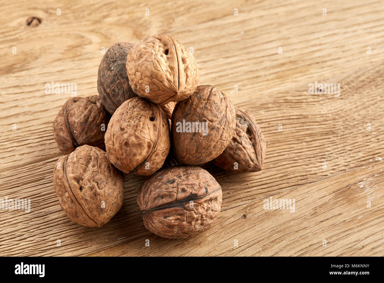 A stack of hard shells of walnuts piled together on dark stony ...