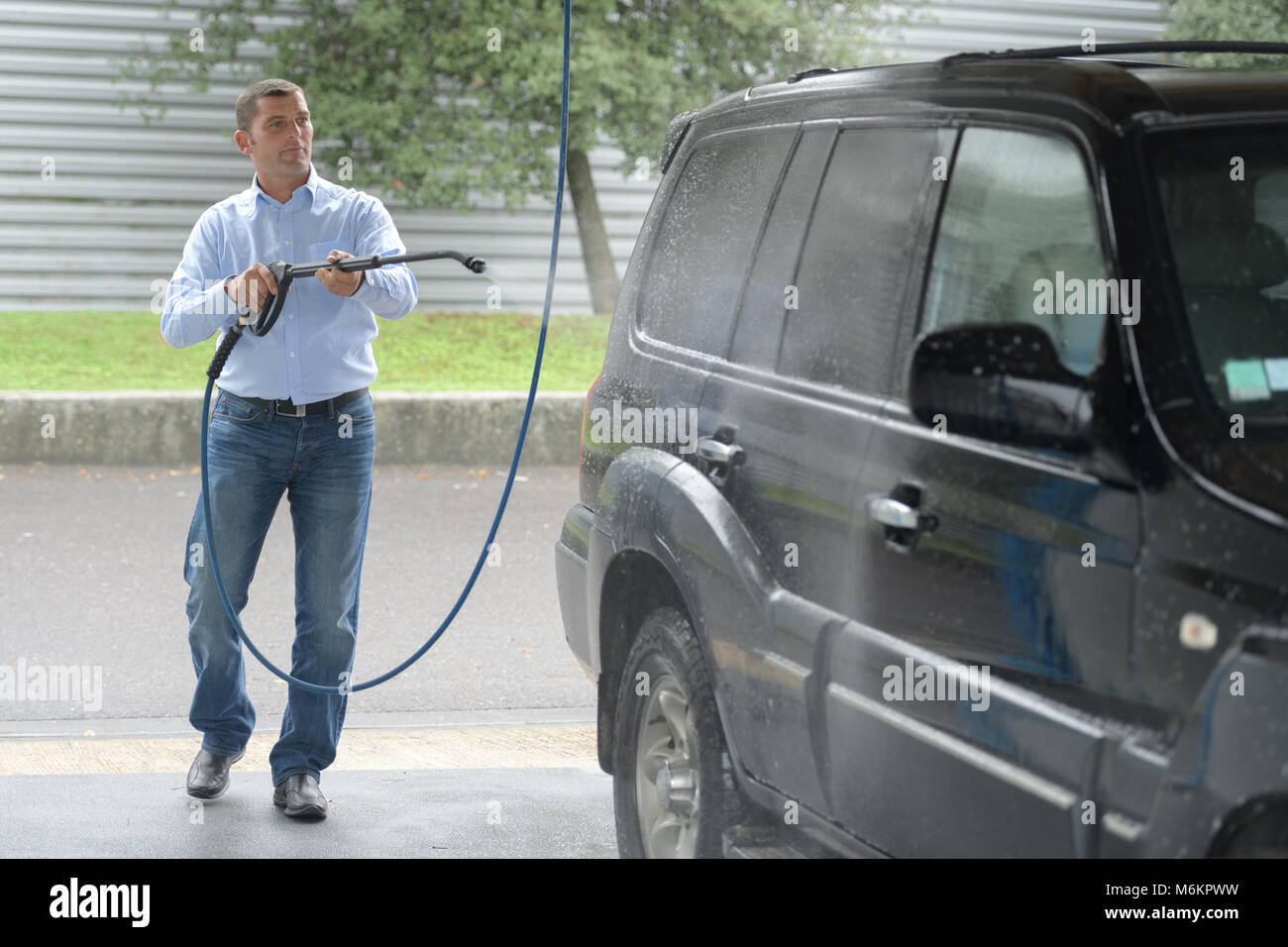 carwash - man working with high pressure washer Stock Photo - Alamy