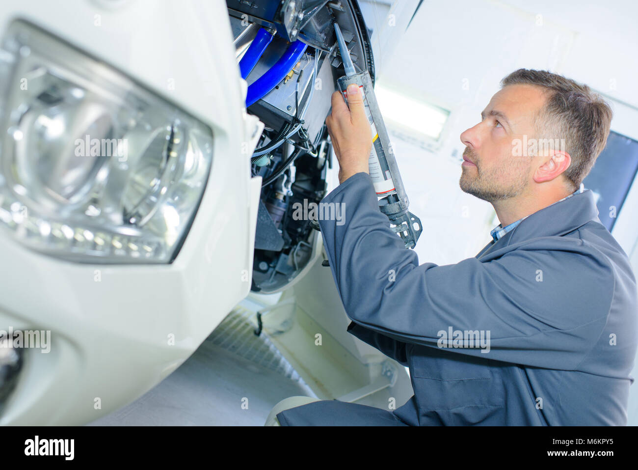Mechanic using silicone gun on vehicle Stock Photo - Alamy