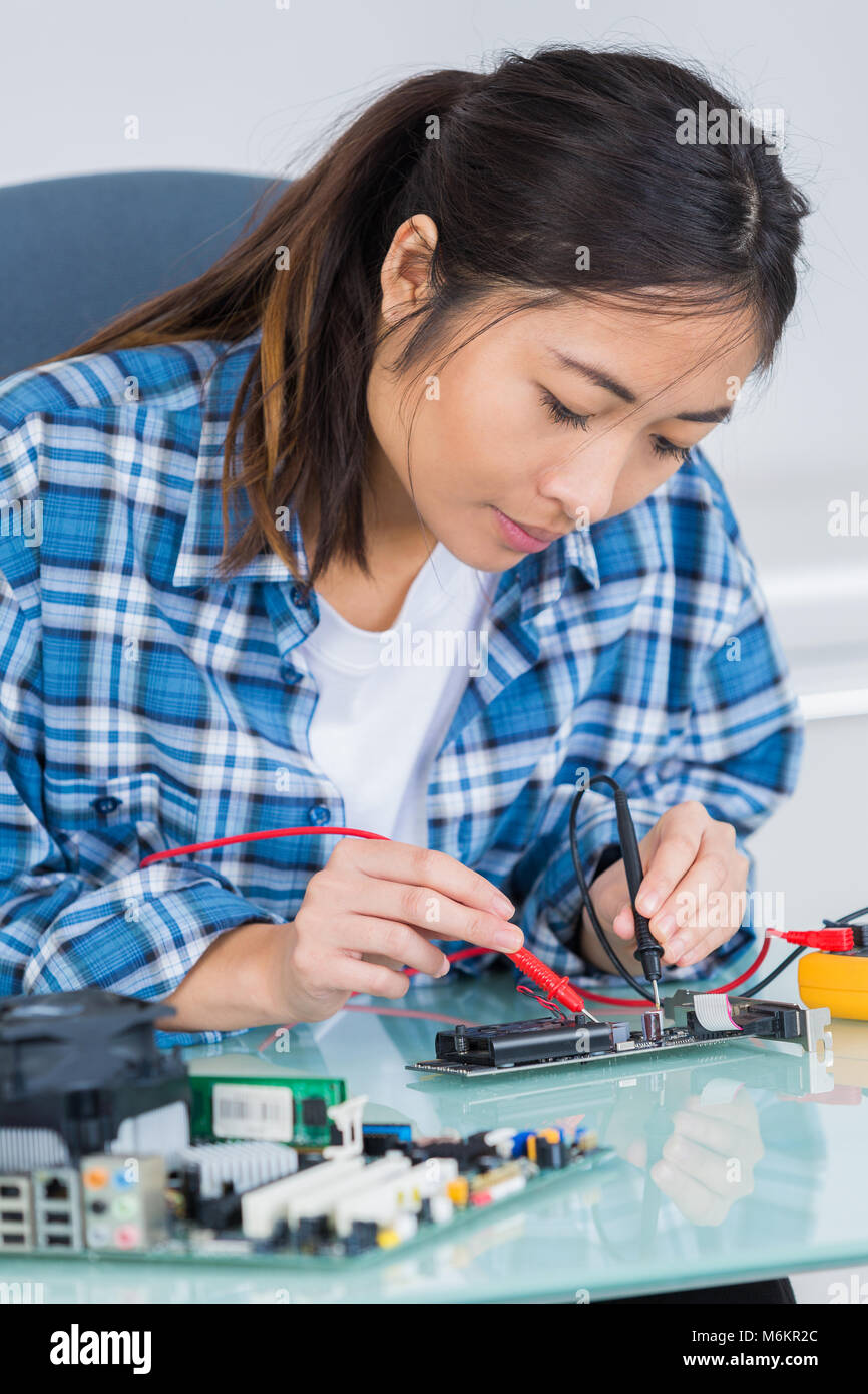 female electrician testing elctronic part Stock Photo - Alamy