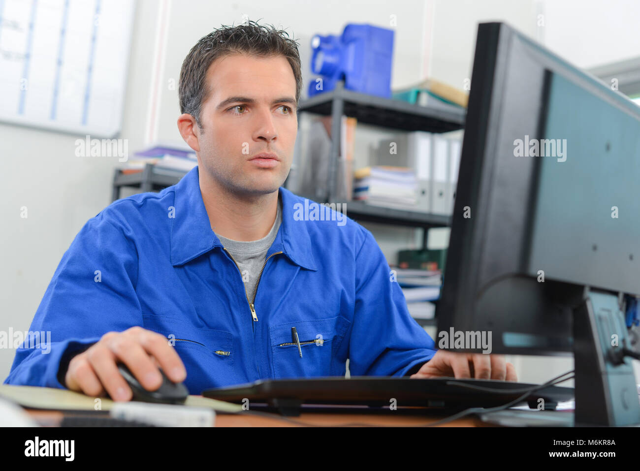 Manual worker sat at his desk Stock Photo - Alamy
