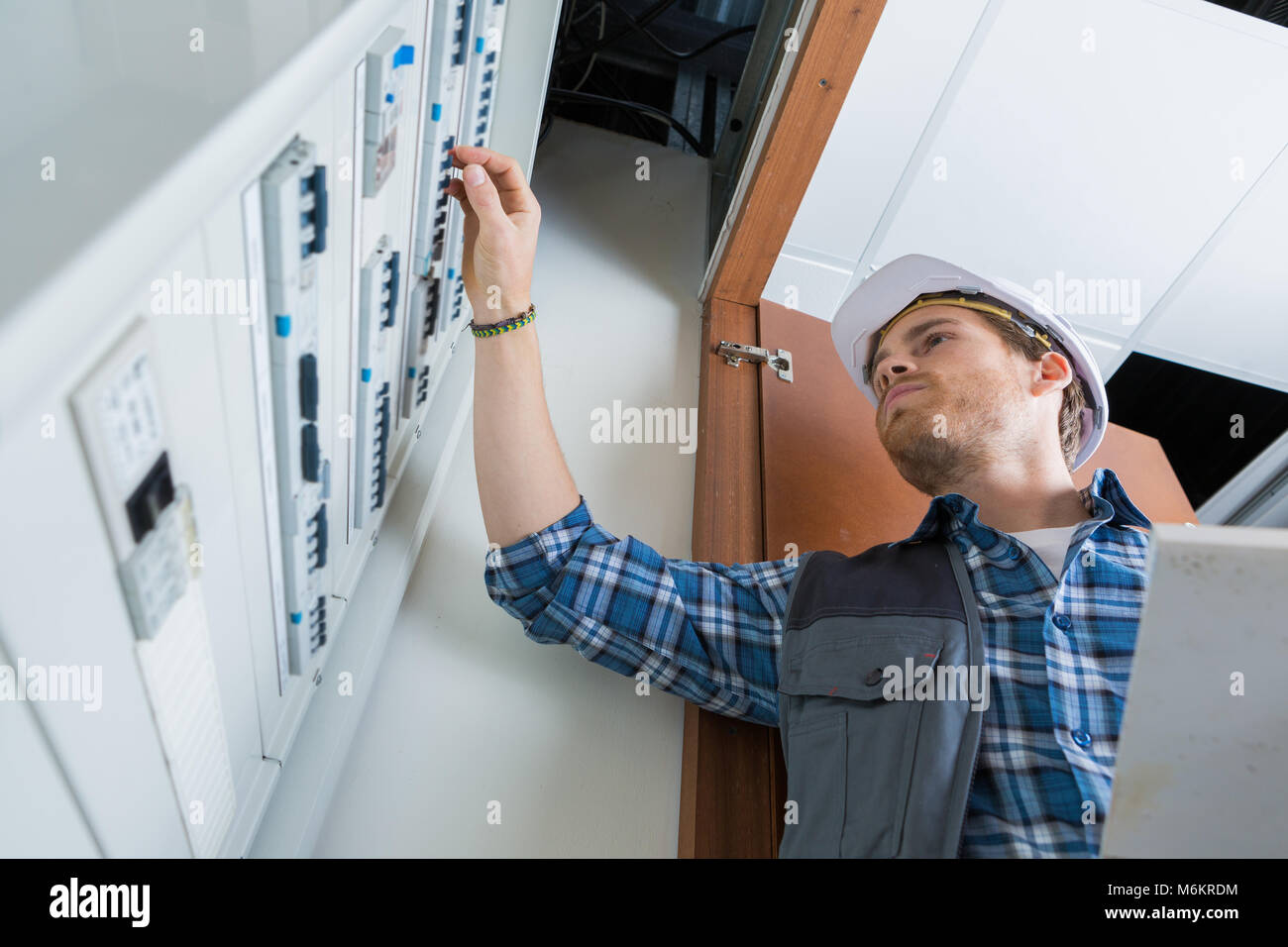 young electrician working on electric panel Stock Photo - Alamy
