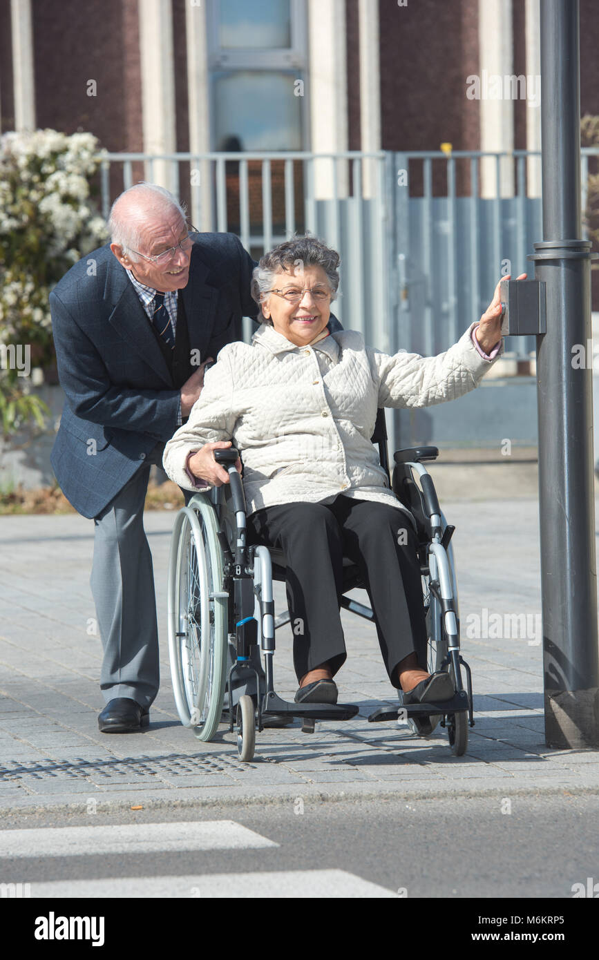 senior man pushing woman in wheelchair Stock Photo - Alamy