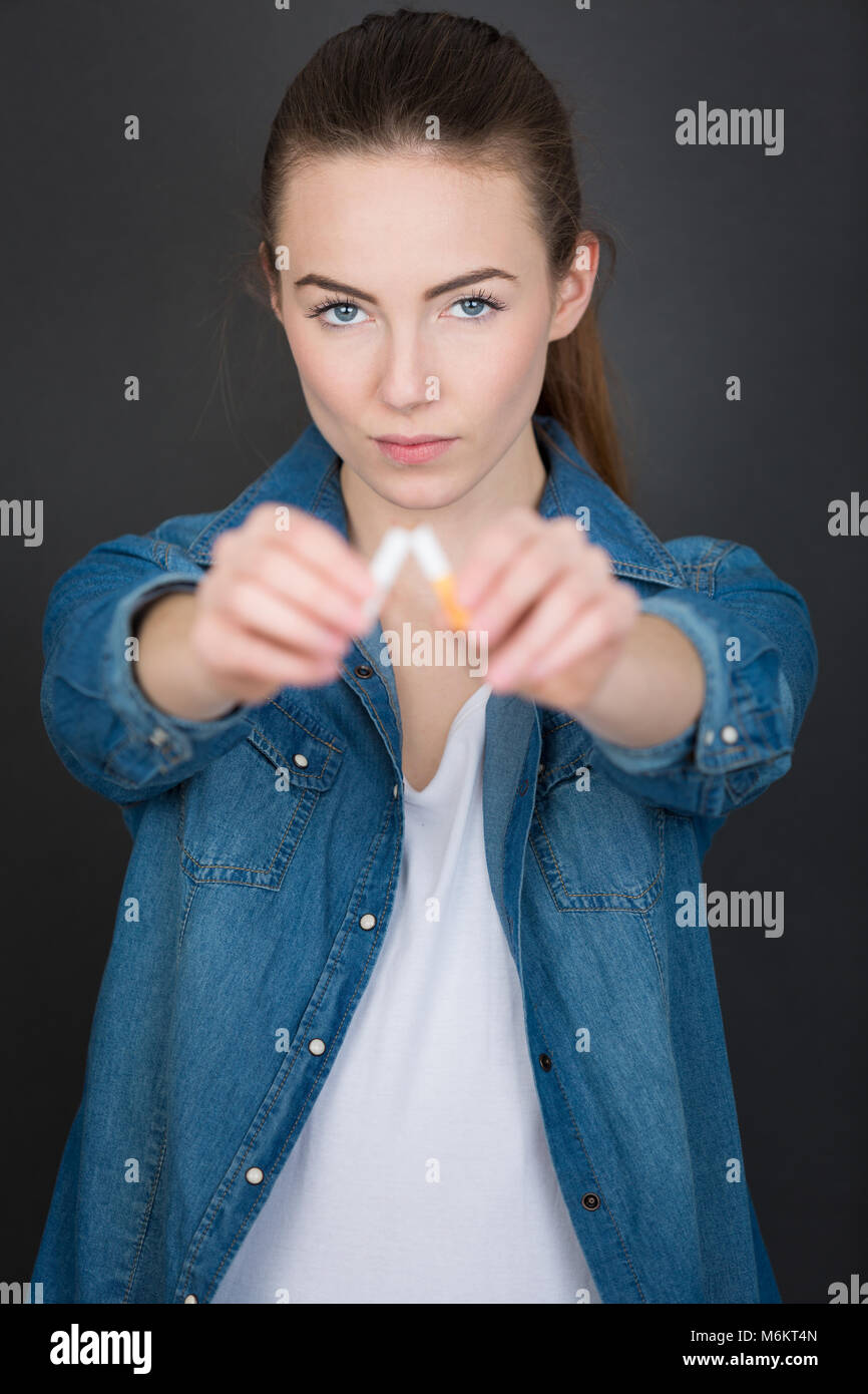 young woman is breaking a cigarette Stock Photo - Alamy