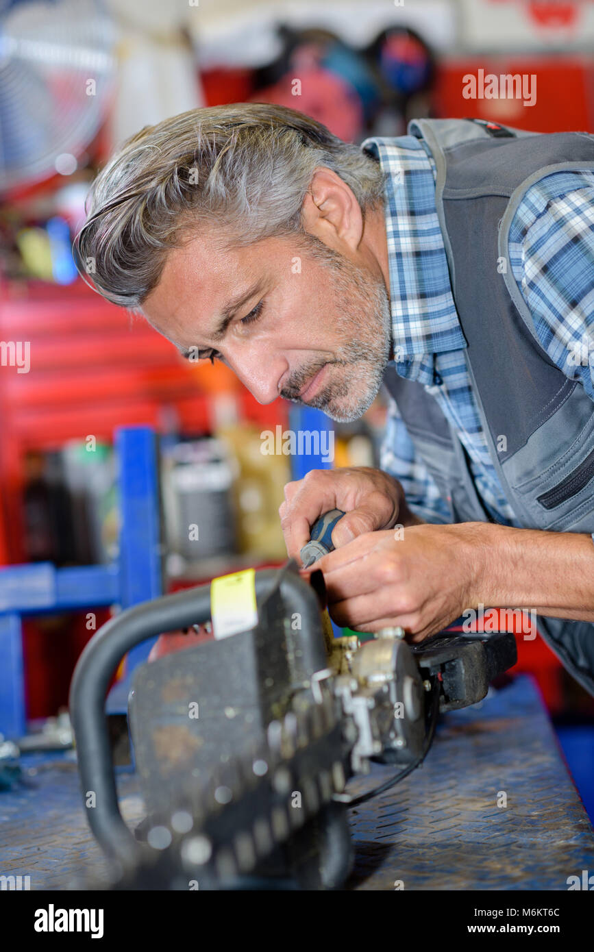 man fixing a chainsaw Stock Photo - Alamy