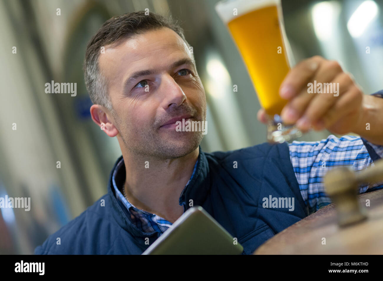 rewer in uniform tasting beer Stock Photo - Alamy