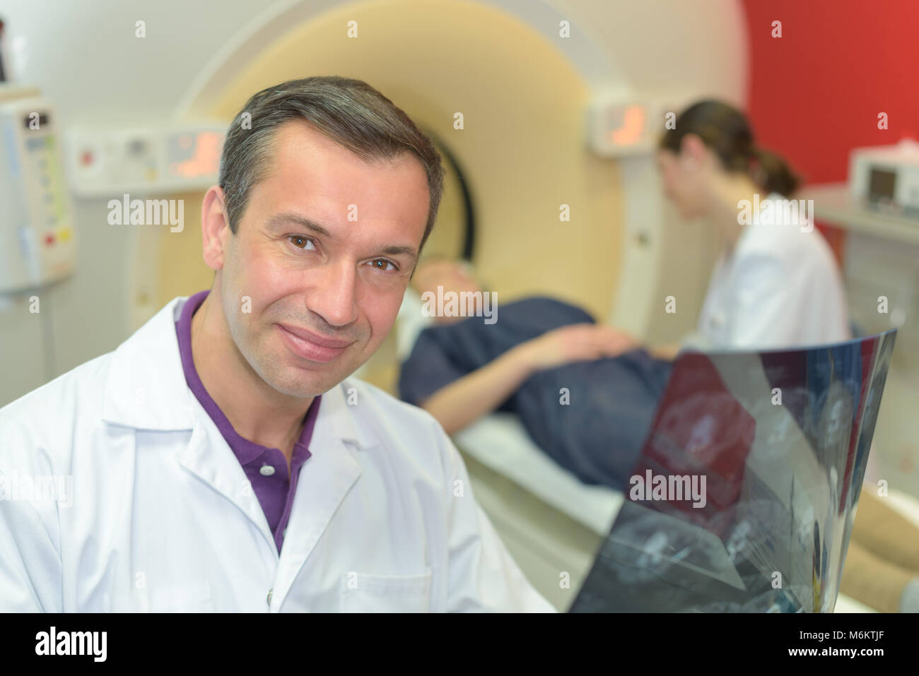 Portrait of doctor by scanning machine Stock Photo - Alamy