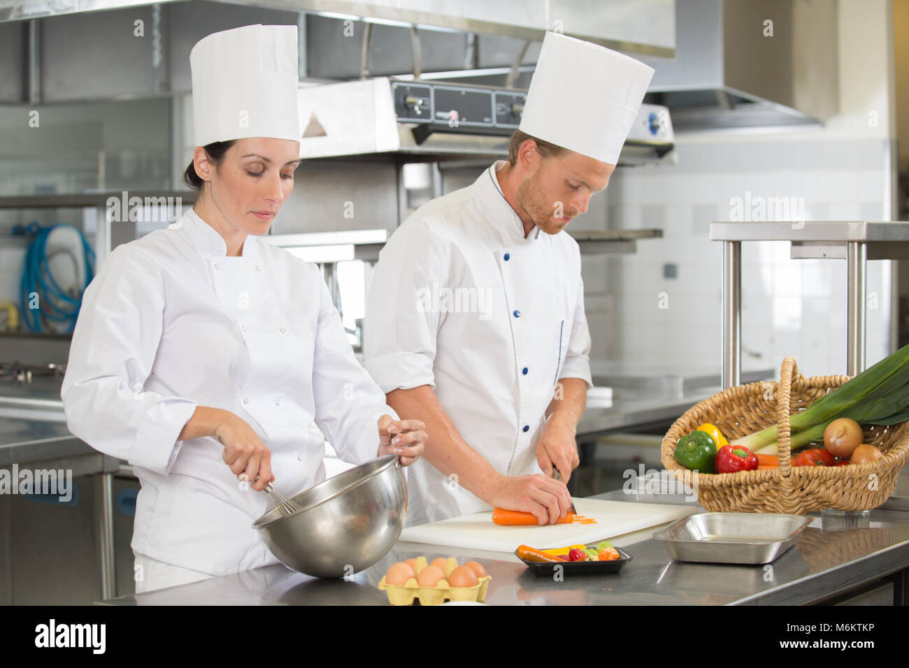 man and woman chefs cooking food at restaurants kitchen Stock Photo - Alamy