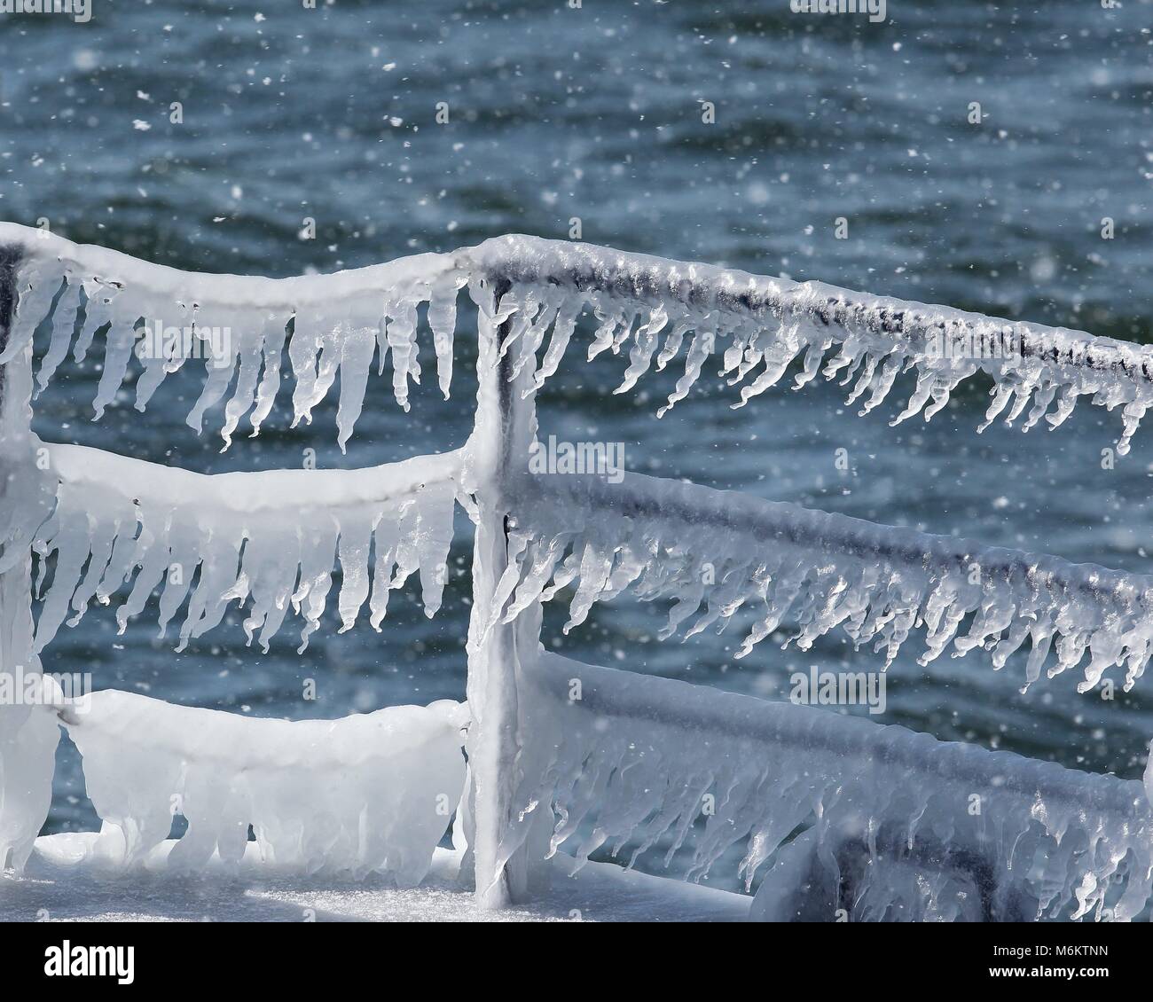 Huge icicles formed by waves hanging on frozen ship's rail, Baltic Sea ...