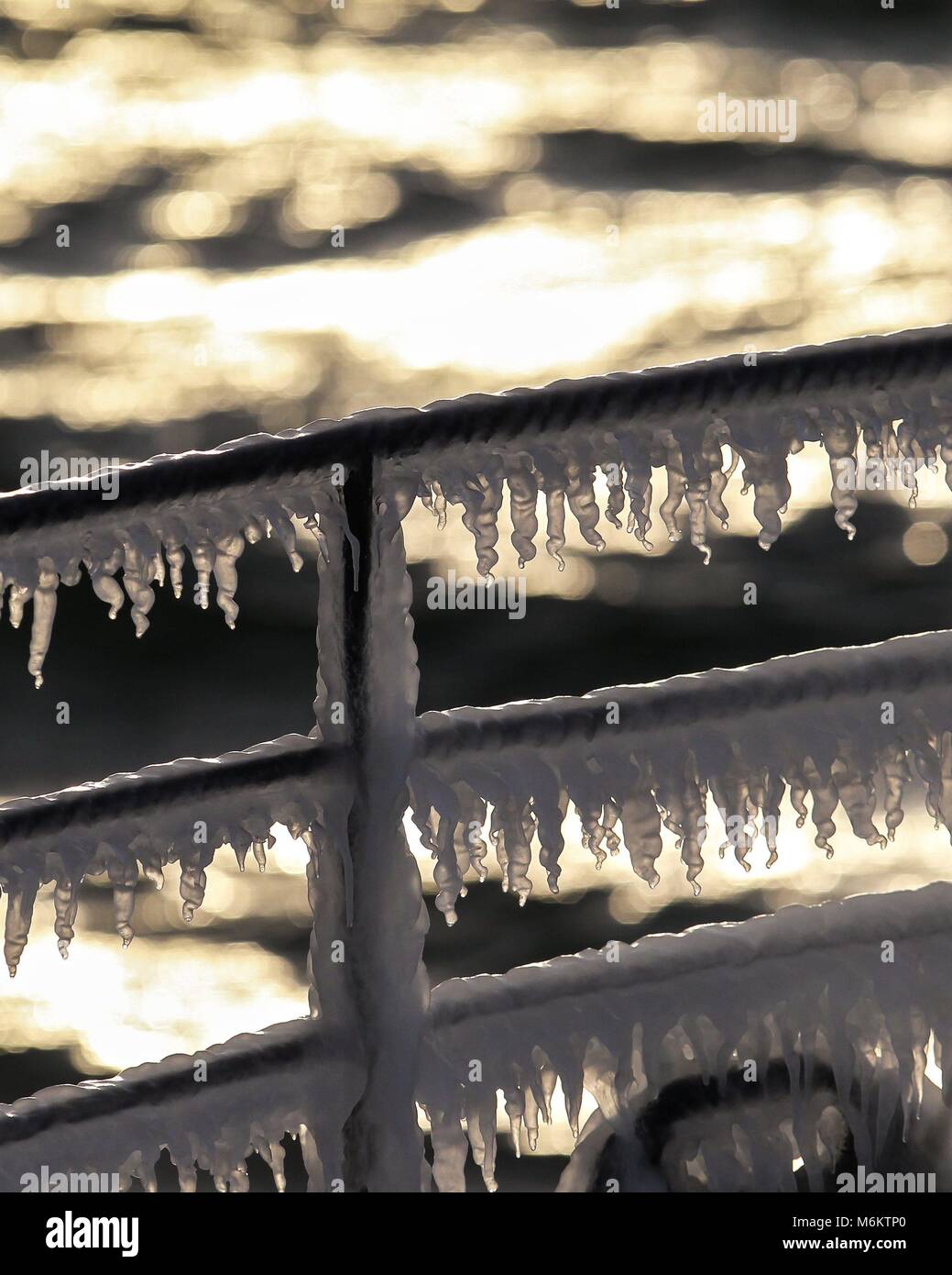 Huge icicles formed by waves hanging on frozen ship's rail, Baltic Sea ...