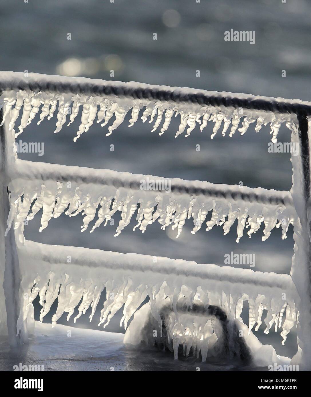 Huge icicles formed by waves hanging on frozen ship's rail, Baltic Sea ...
