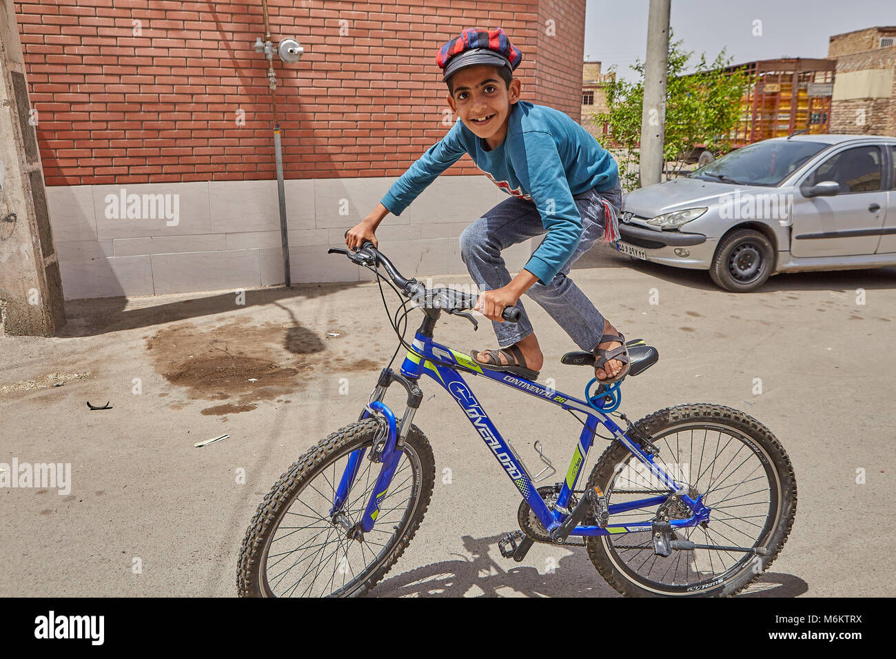 Kashan, Iran - April 27, 2017: One unknown Iranian young man shows the ability to ride a bicycle ...