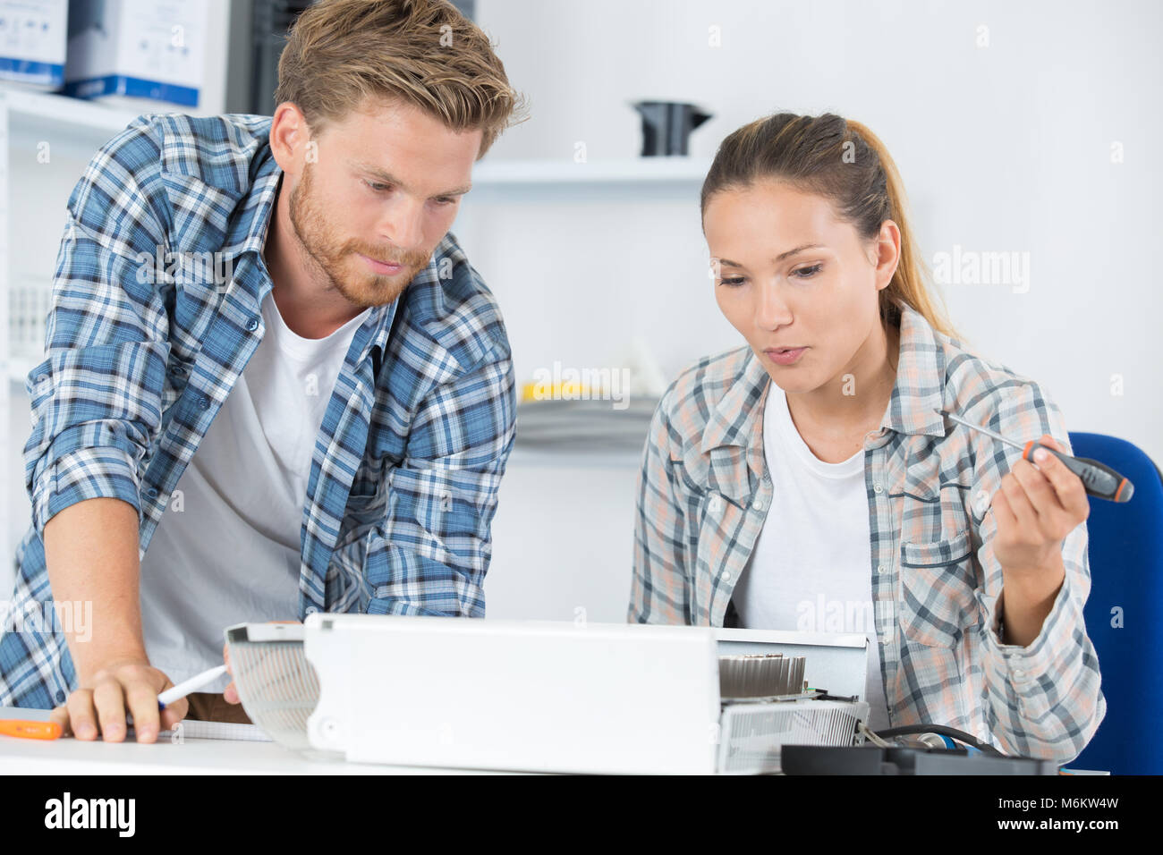 couple fixing computer together Stock Photo - Alamy