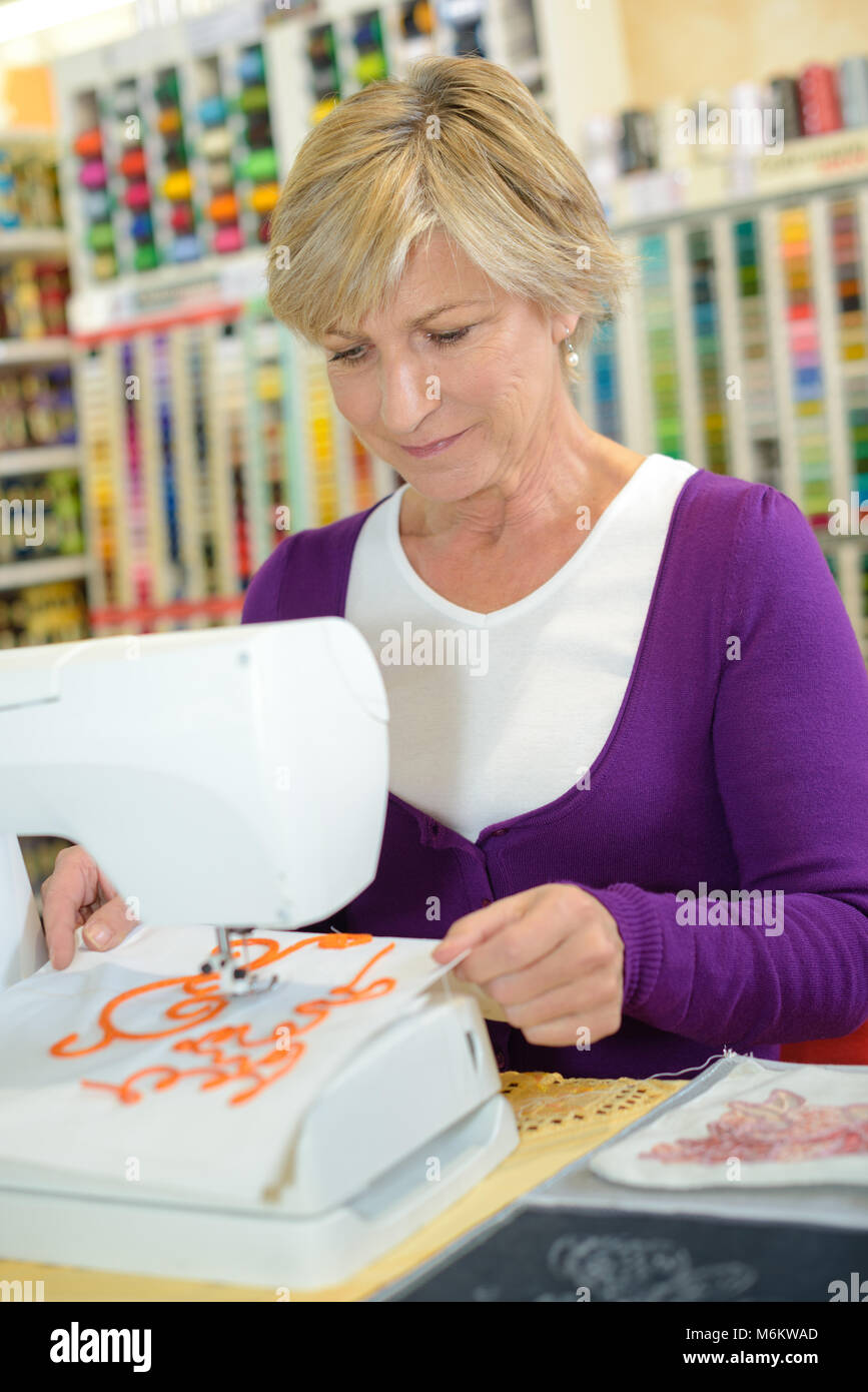 Senior lady using sewing machine Stock Photo - Alamy