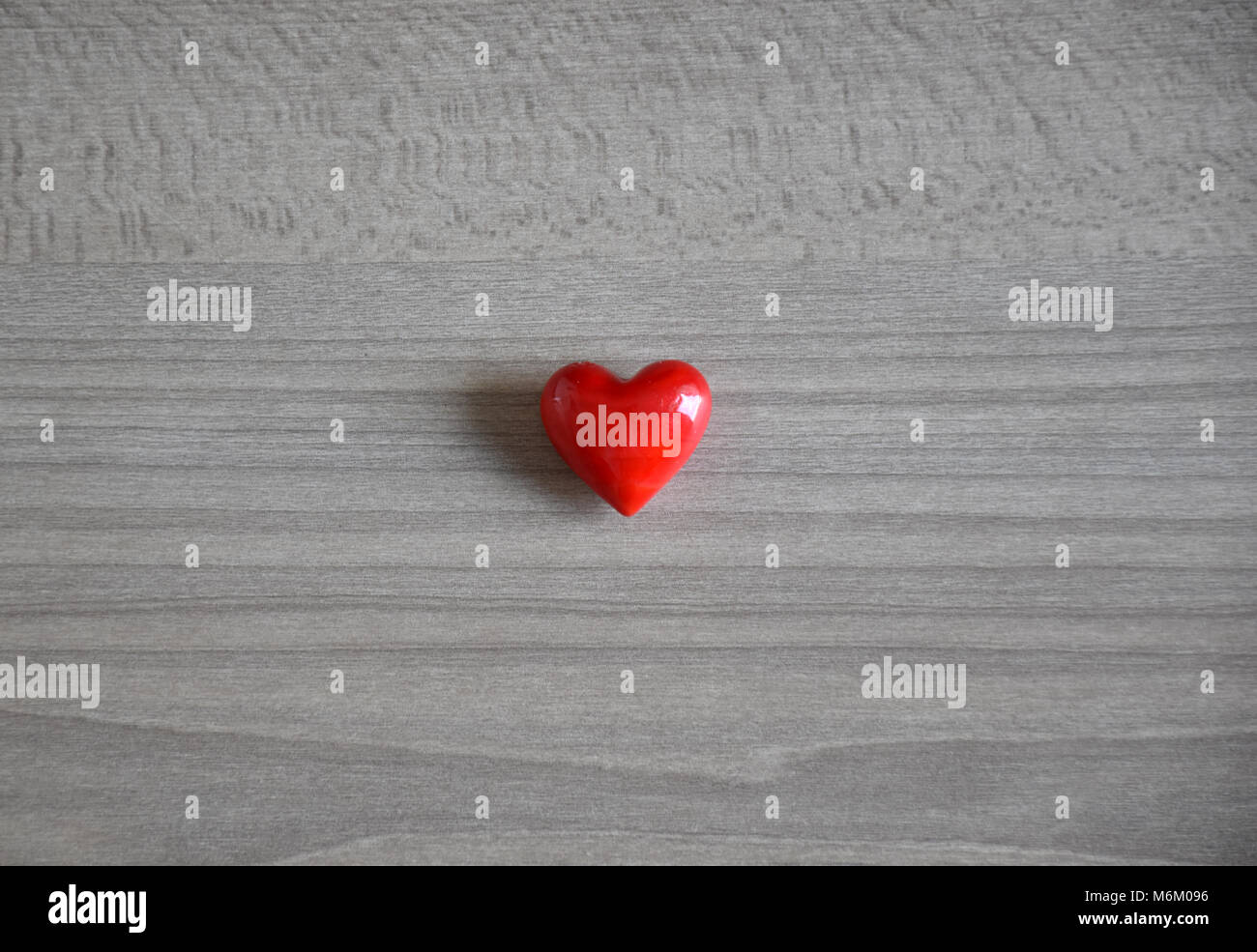 Small red love heart pebble stone against a simple background Stock ...