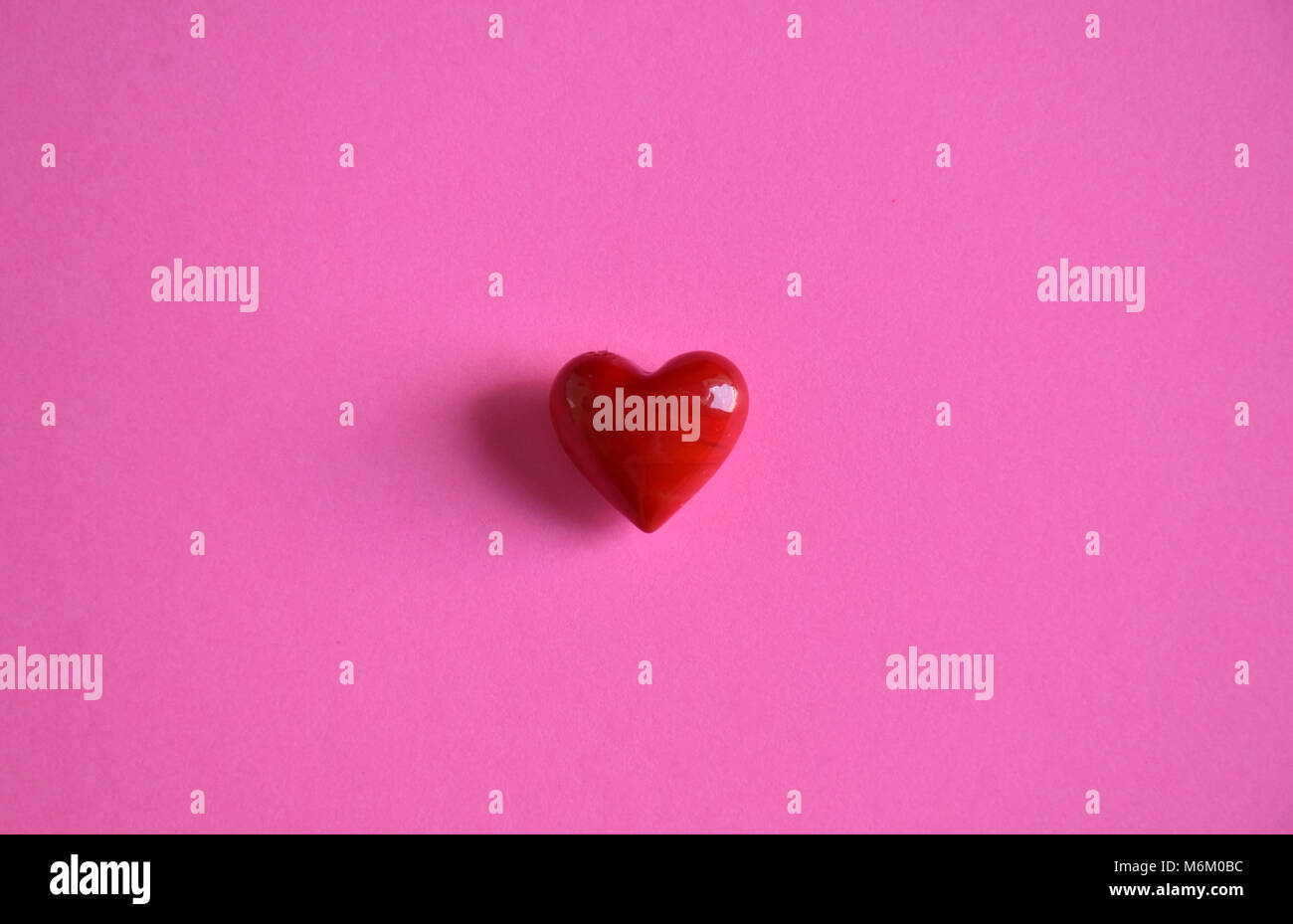 Small red love heart pebble stone against a simple background Stock ...