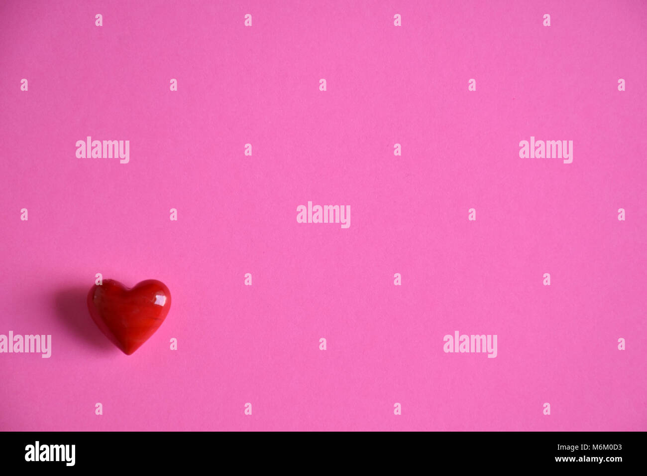 Small red love heart pebble stone against a simple background Stock ...