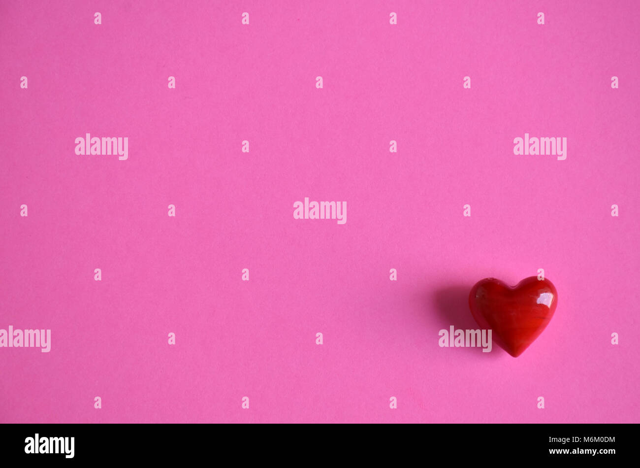 Small red love heart pebble stone against a simple background Stock ...