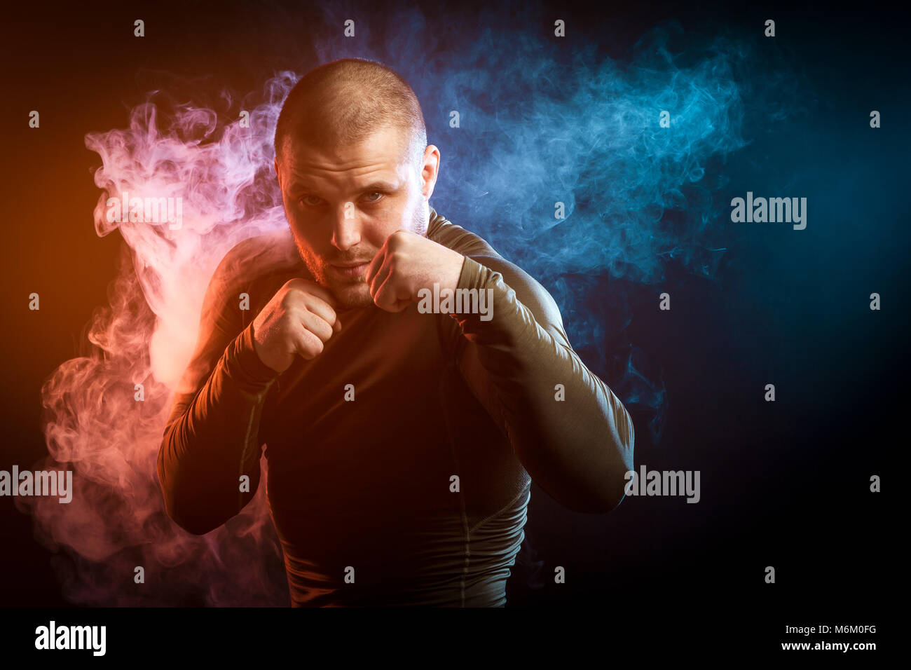 A strong young dark-haired male athlete in a green sports jacket is ...