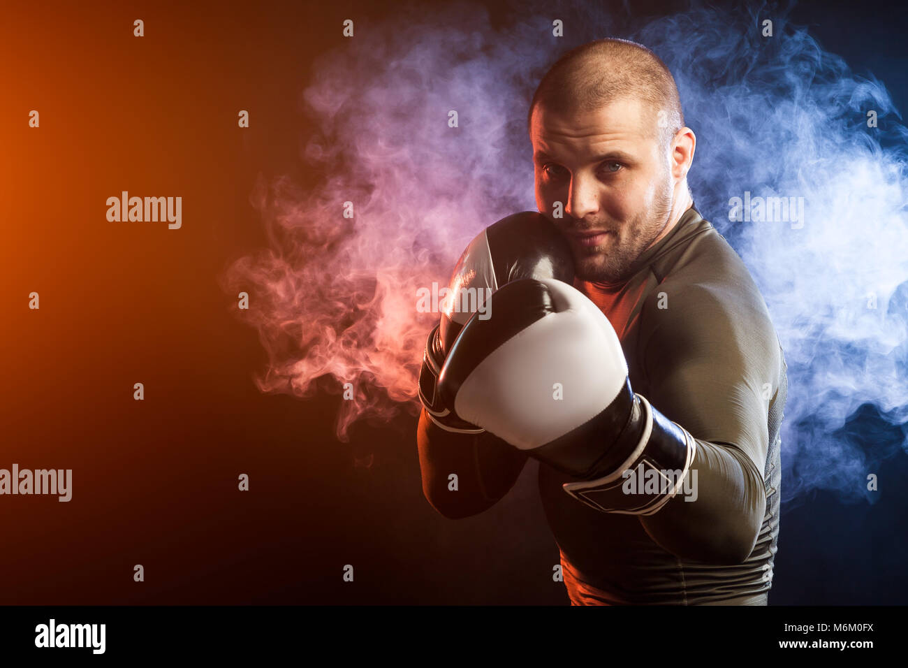 A strong young dark-haired male athlete in a green sports jacket, in ...