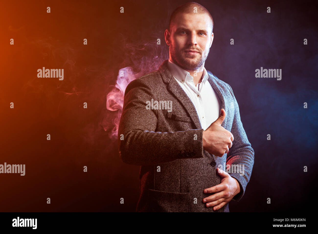 Young intelligent man businessman in white shirt and gray suit is ...