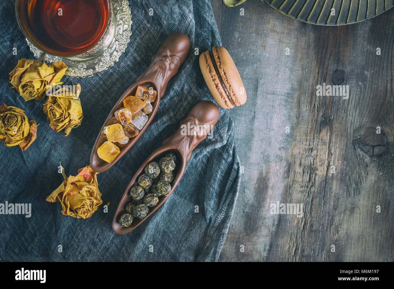 A Cup of brewed black tea. Two ceramic spatulas with caramel sugar and ...