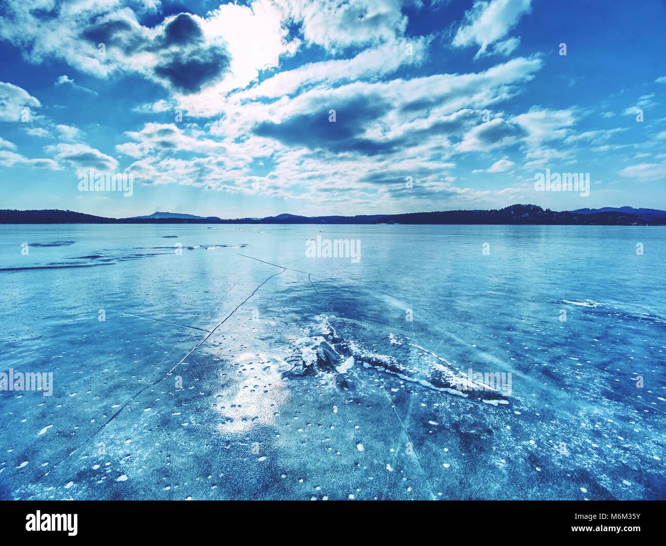 Ice shards on a frozen lake. The rays of the sun creat rainbow shadows ...
