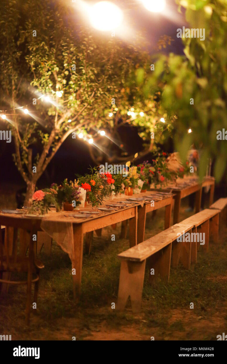 Prepared table for a rustic outdoor dinner at night with wineglasses ...