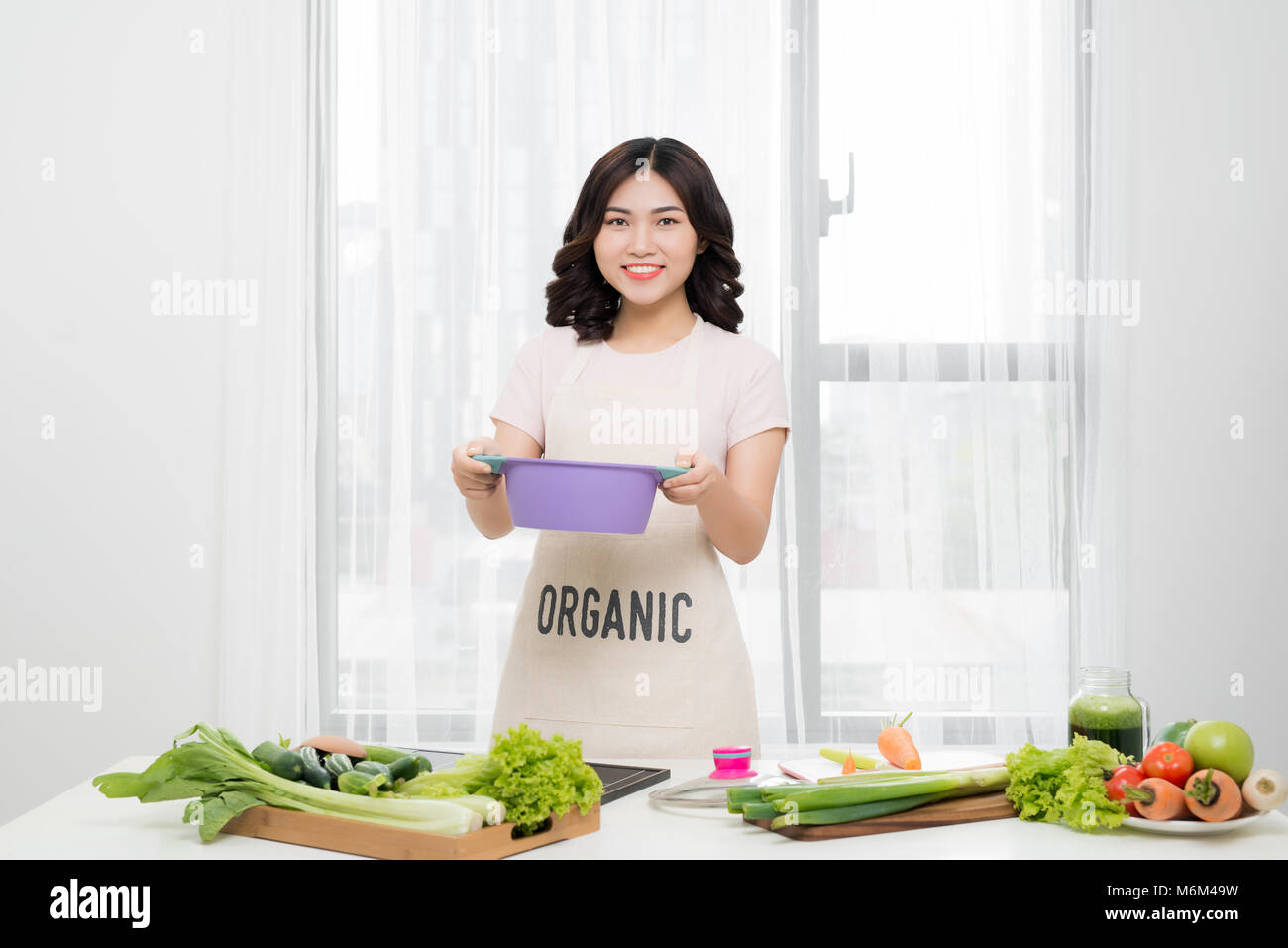 Healthy food. Asian woman cooking in the kitchen with wooden spoon ...