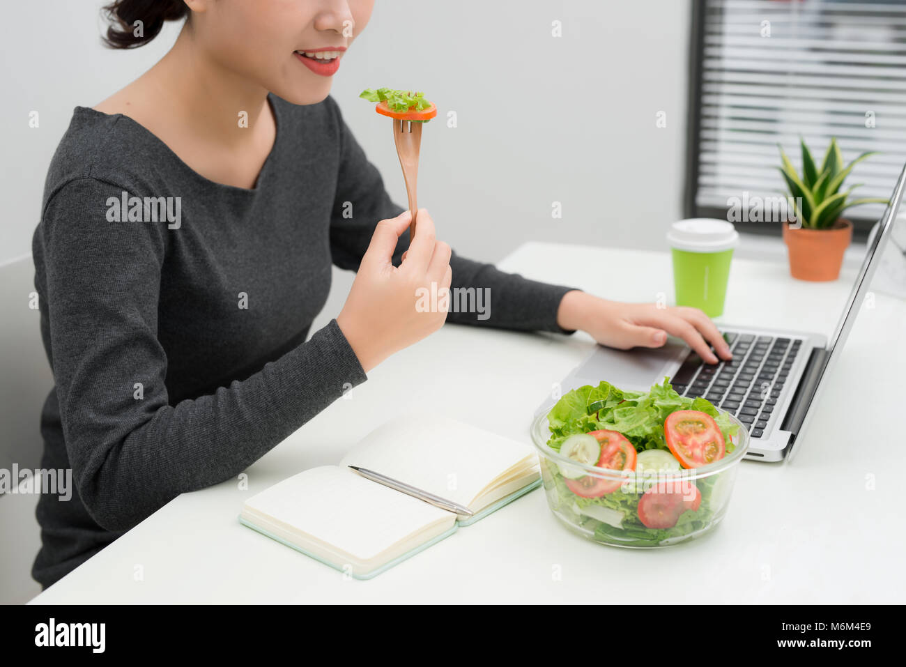 Woman eating lunch at desk hi-res stock photography and images - Alamy