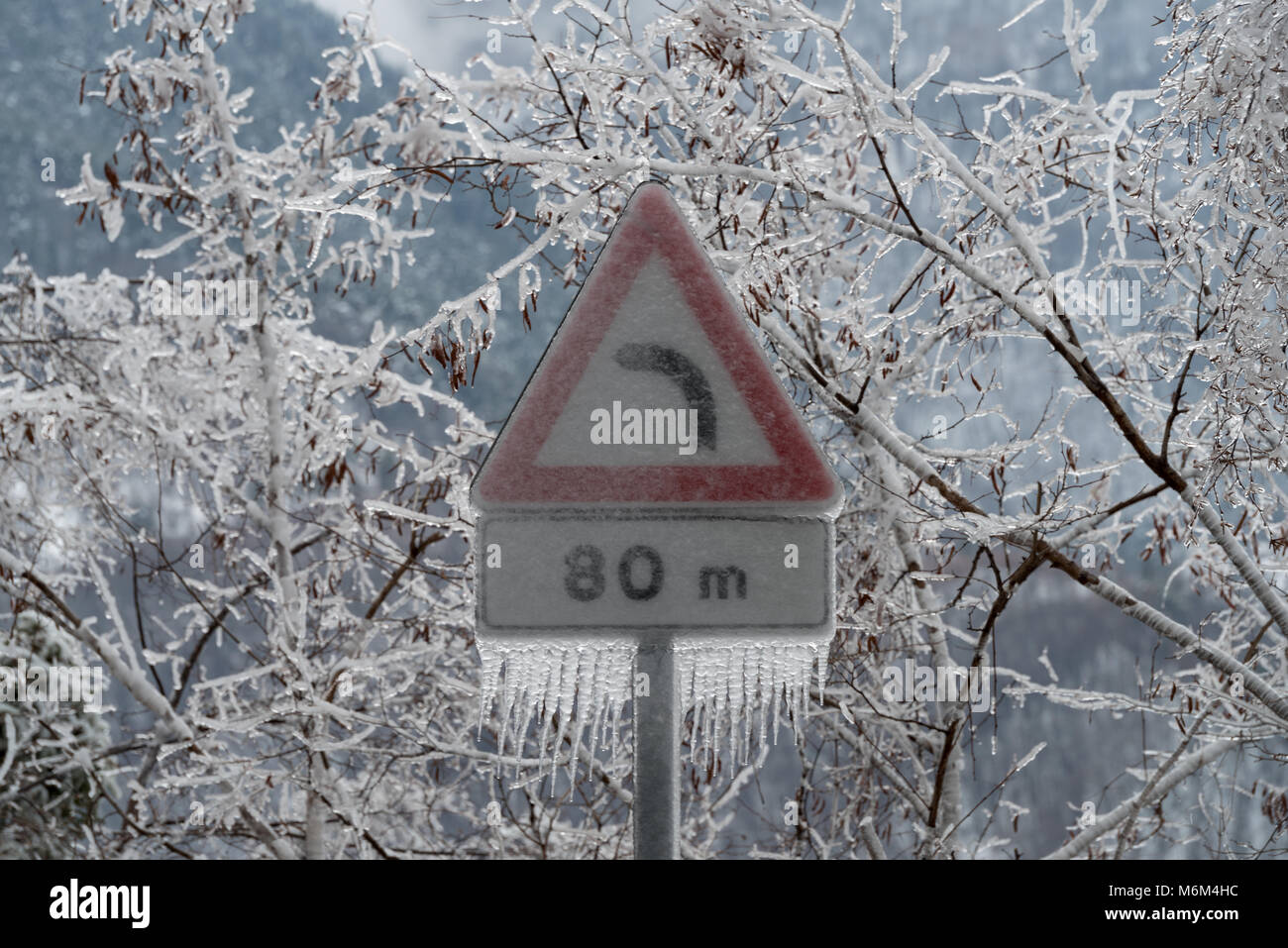 Road sign danger curve covered in ice after the freezing rain Stock ...