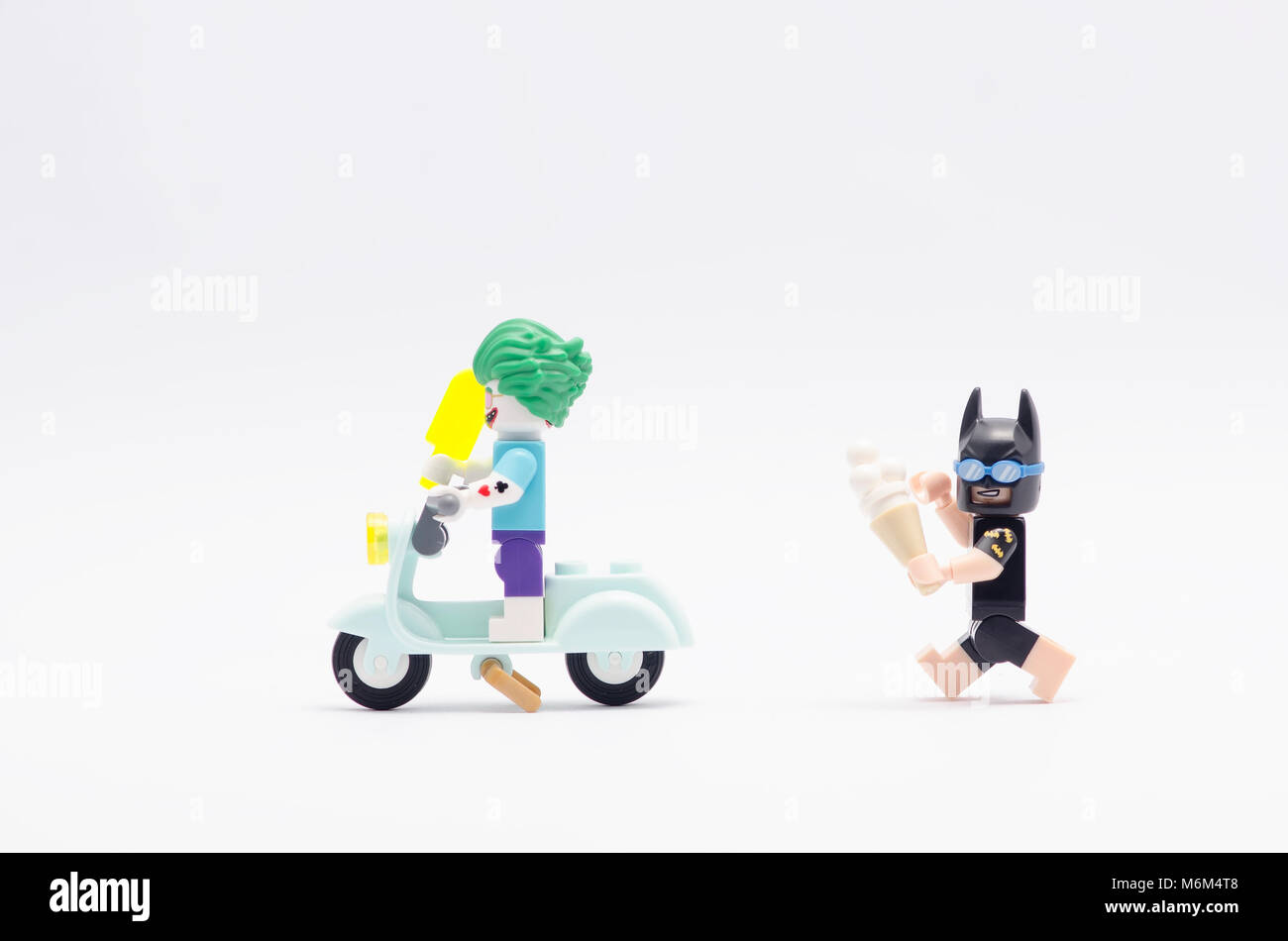 lego batman chasing joker riding scooter. isolated on white background ...