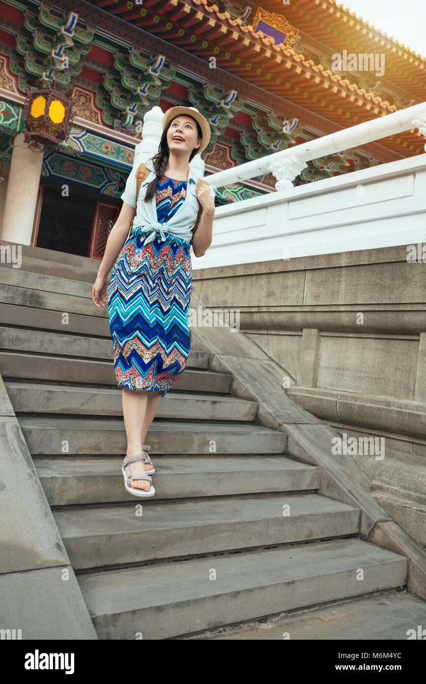 Asian woman visiting old chinese temple walking on stair step on summer ...
