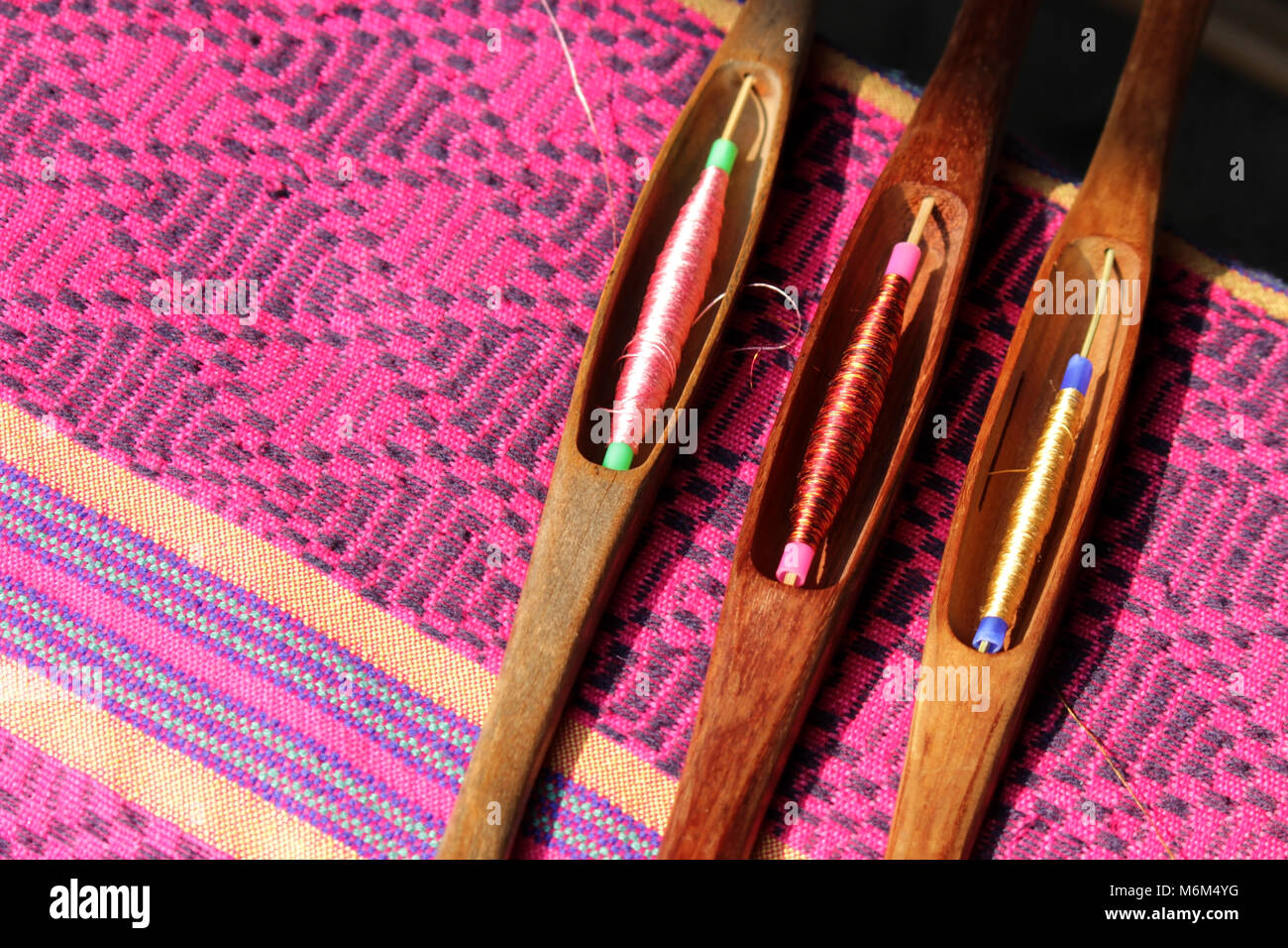 colorful thread in wooden bobbin on silk fabric, traditional weaving of ...