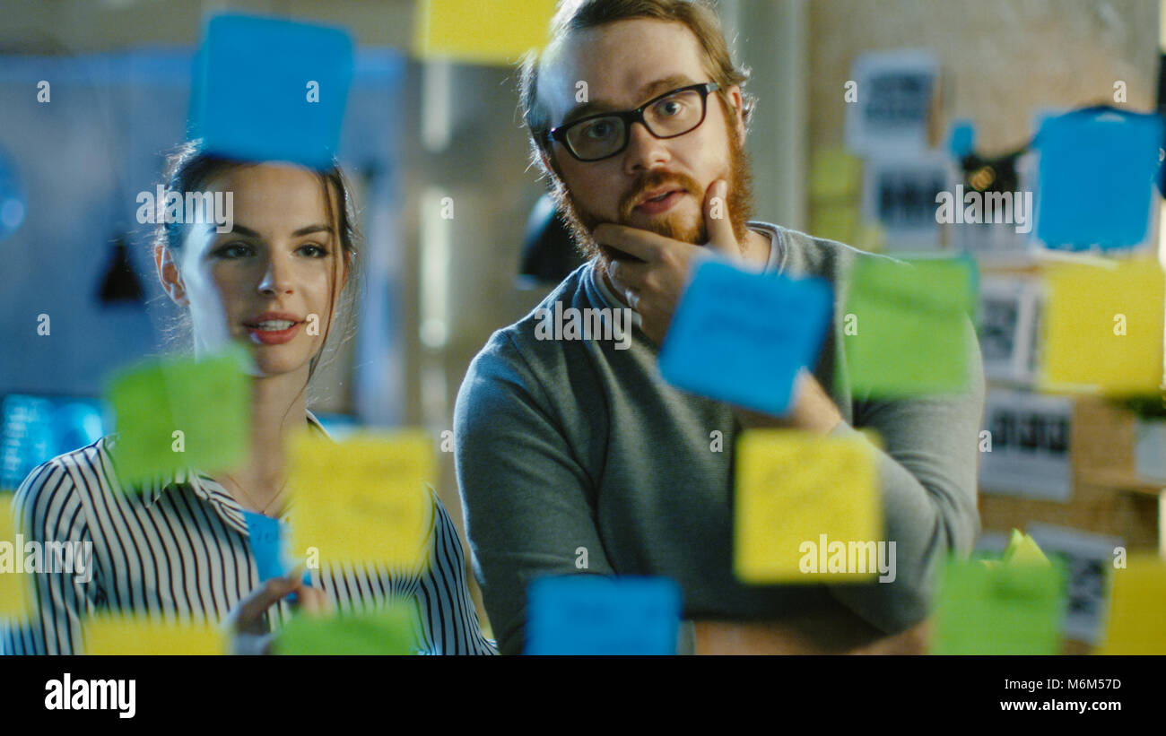 Male and Female Designers Plan Their Next Project on a Glass Wall with ...