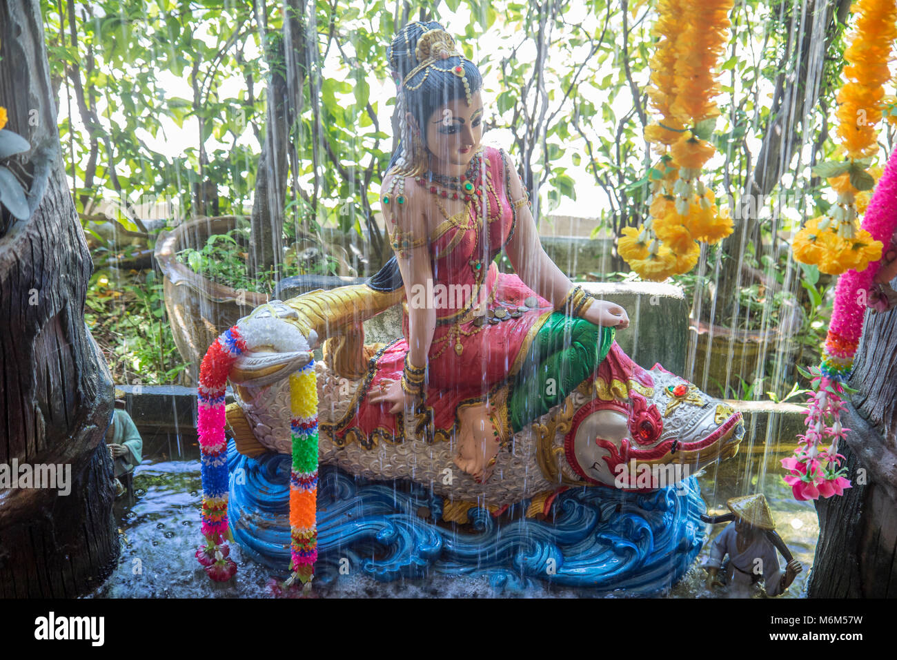 Phra Mae Thorani, goddess from Buddhist mythology, behind water of ...