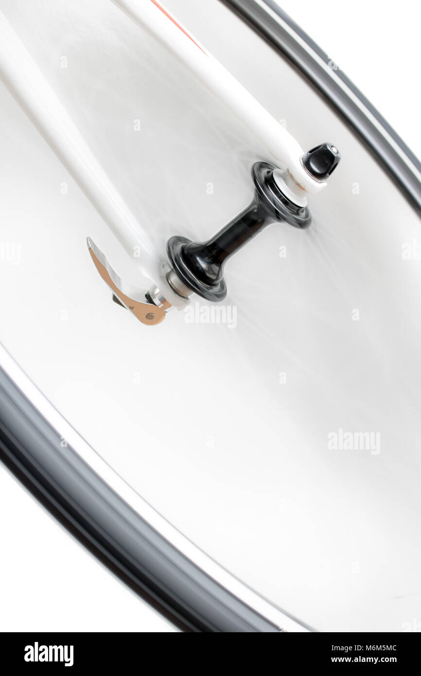 The front wheel of the bicycle rotates quickly on a white background ...