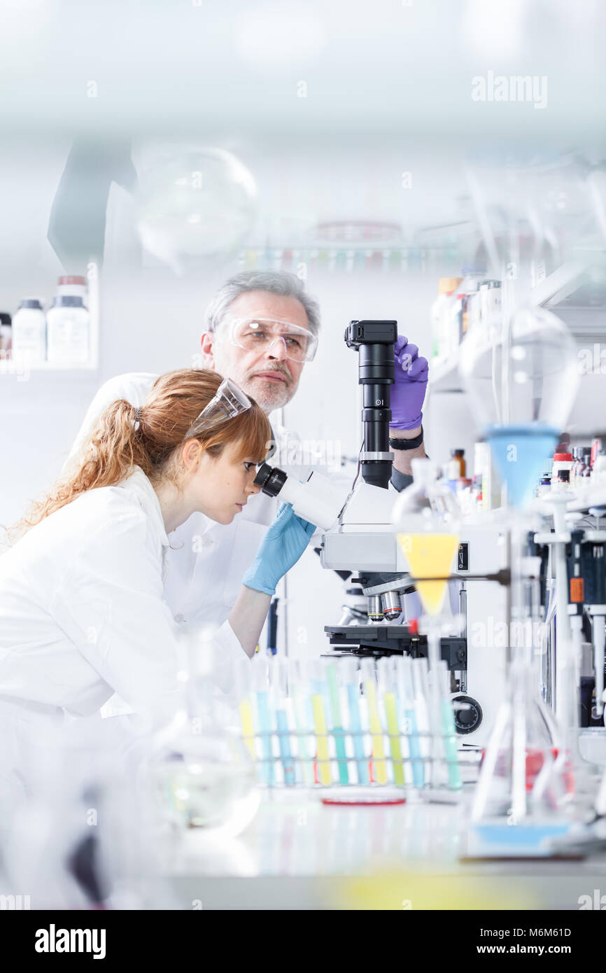 Health care researchers microscoping in scientific laboratory Stock ...