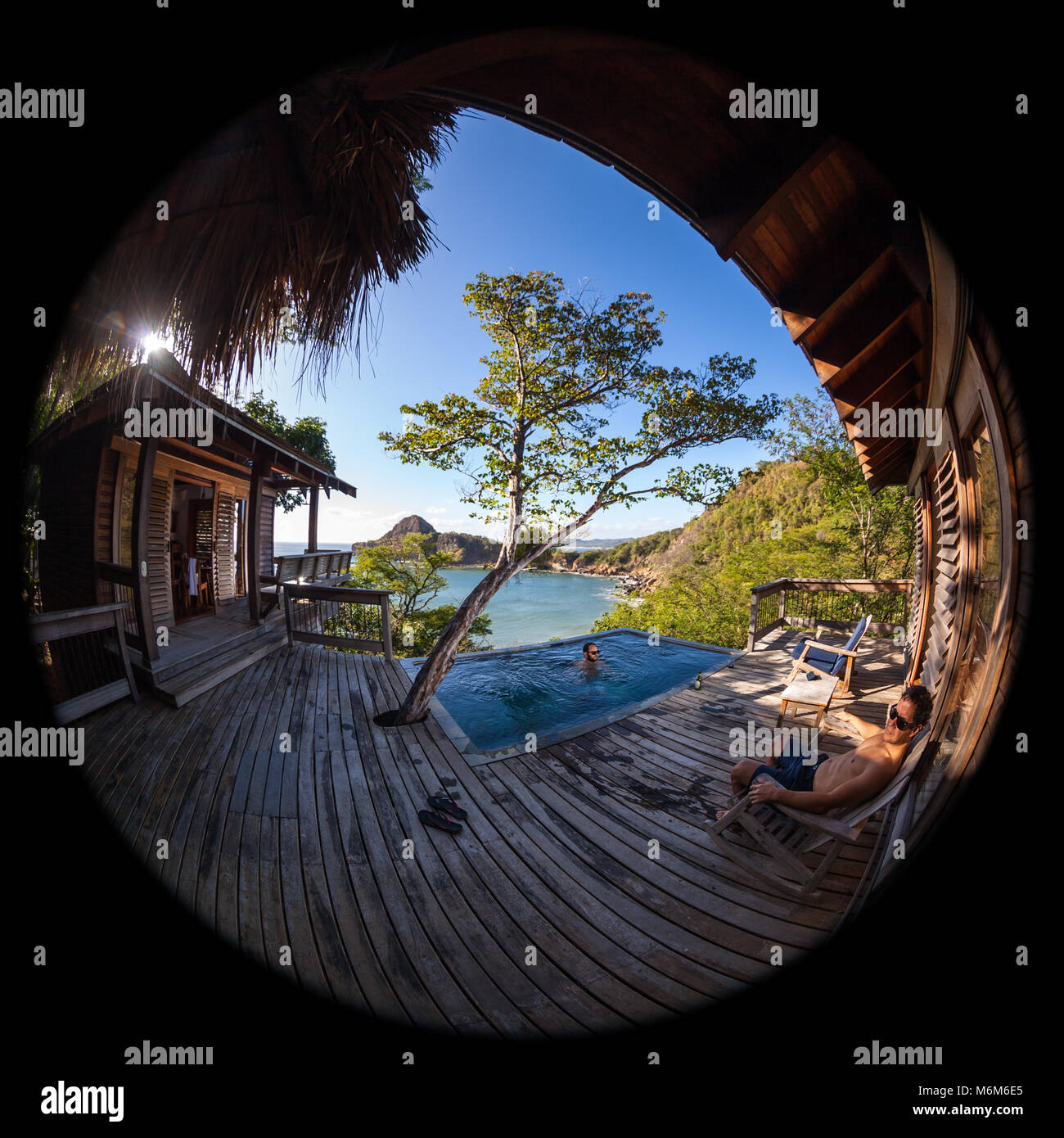 two men relaxing in a peaceful pool overlooking the pacific ocean in ...