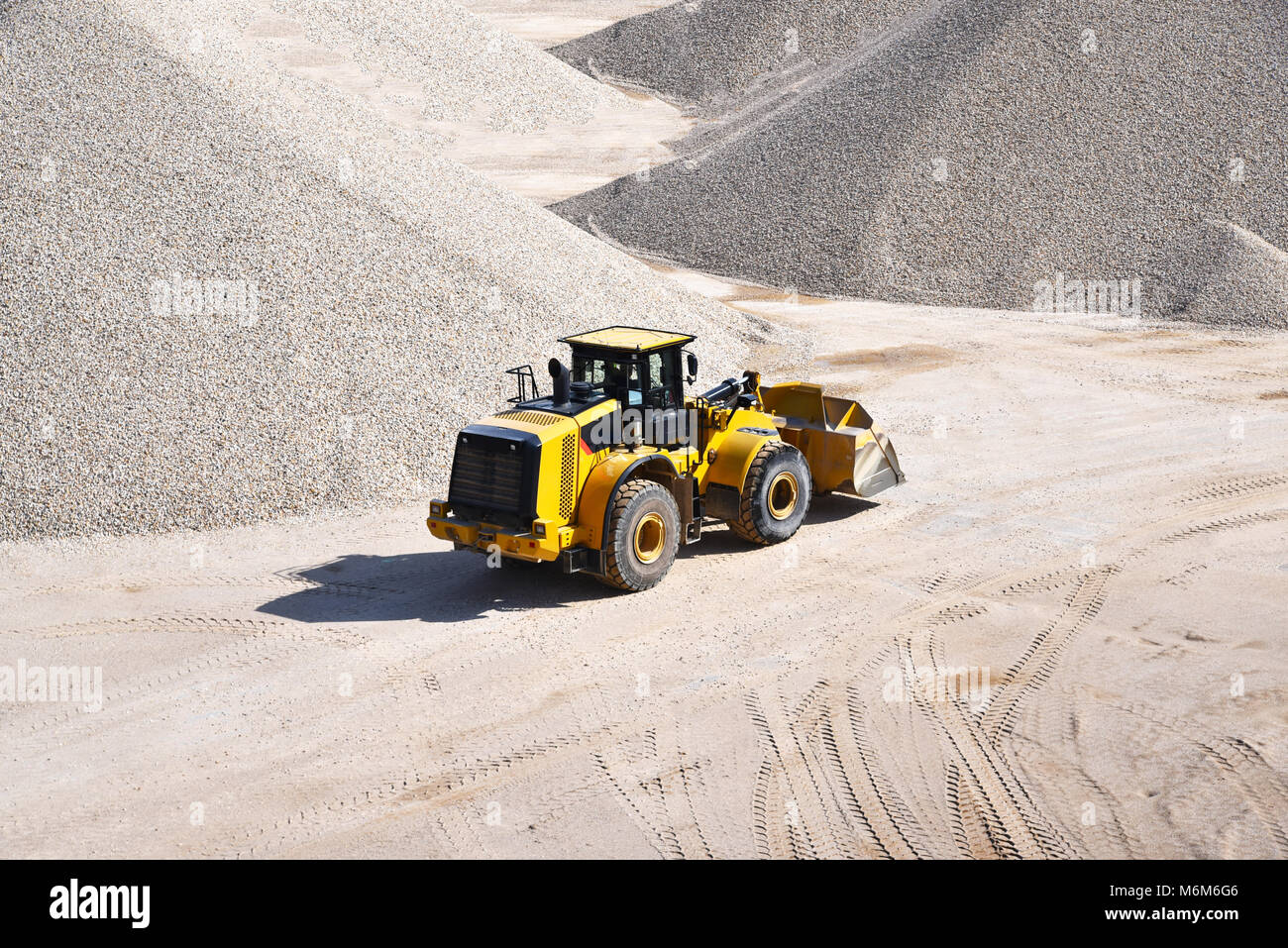 wheel loader drives in a gravel plant and transports mined sand - open ...