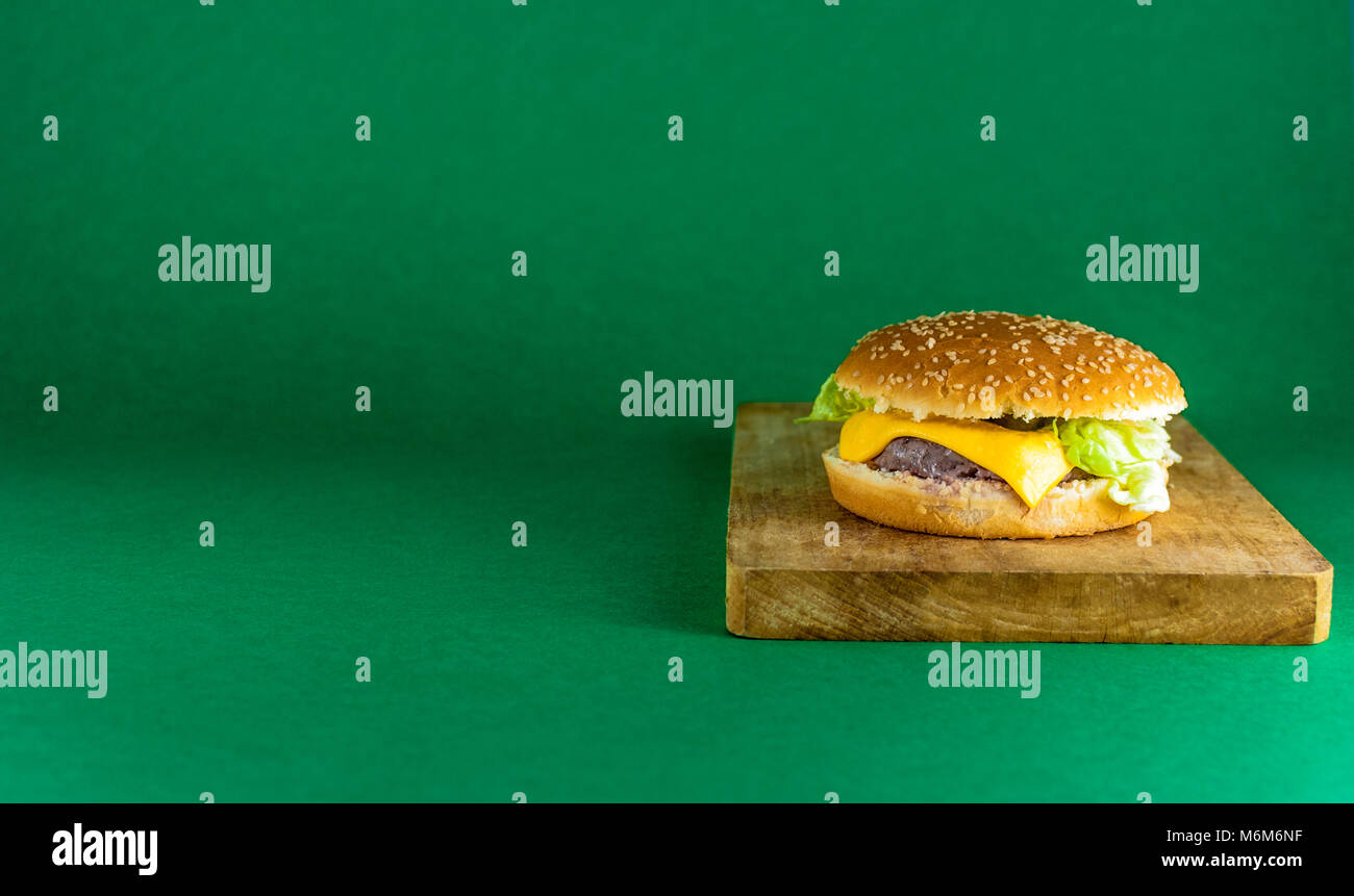 Isolated cheeseburger on green background Stock Photo - Alamy