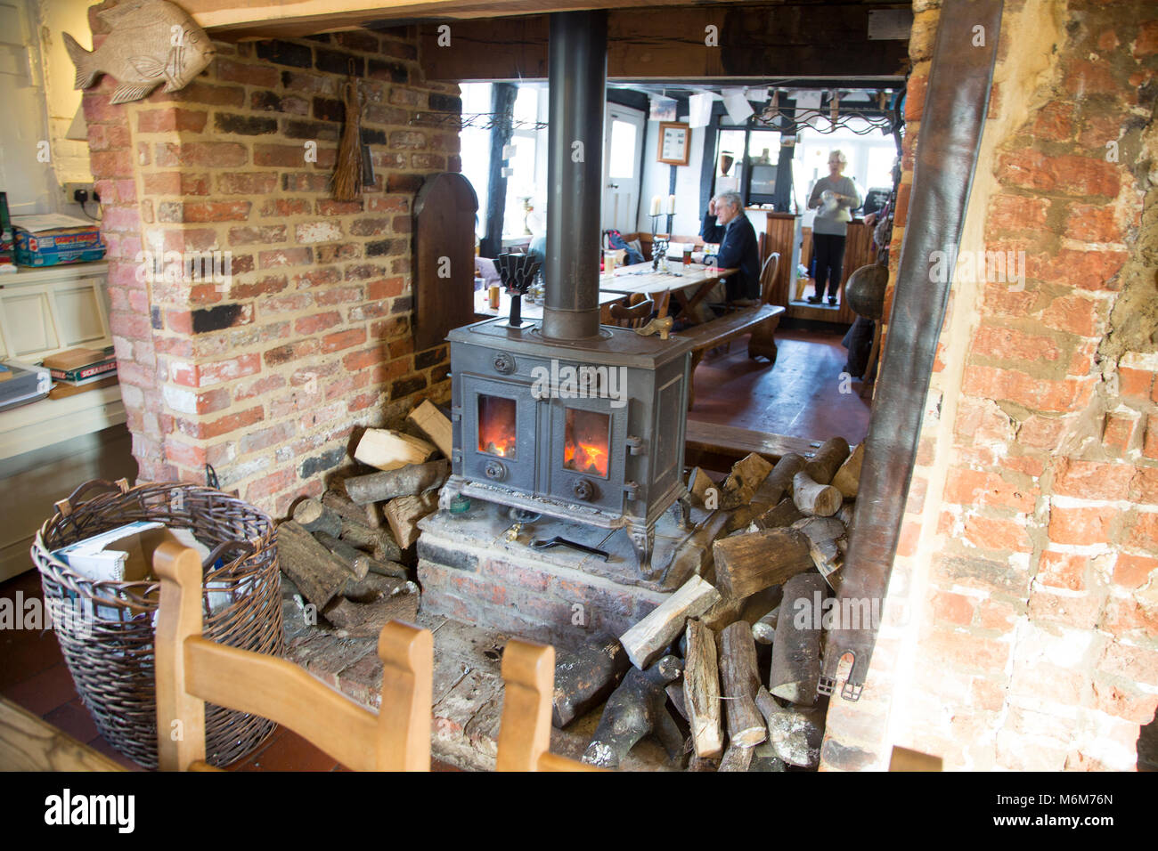 Fireplace customers at tables inside public bar of White Lion pub ...