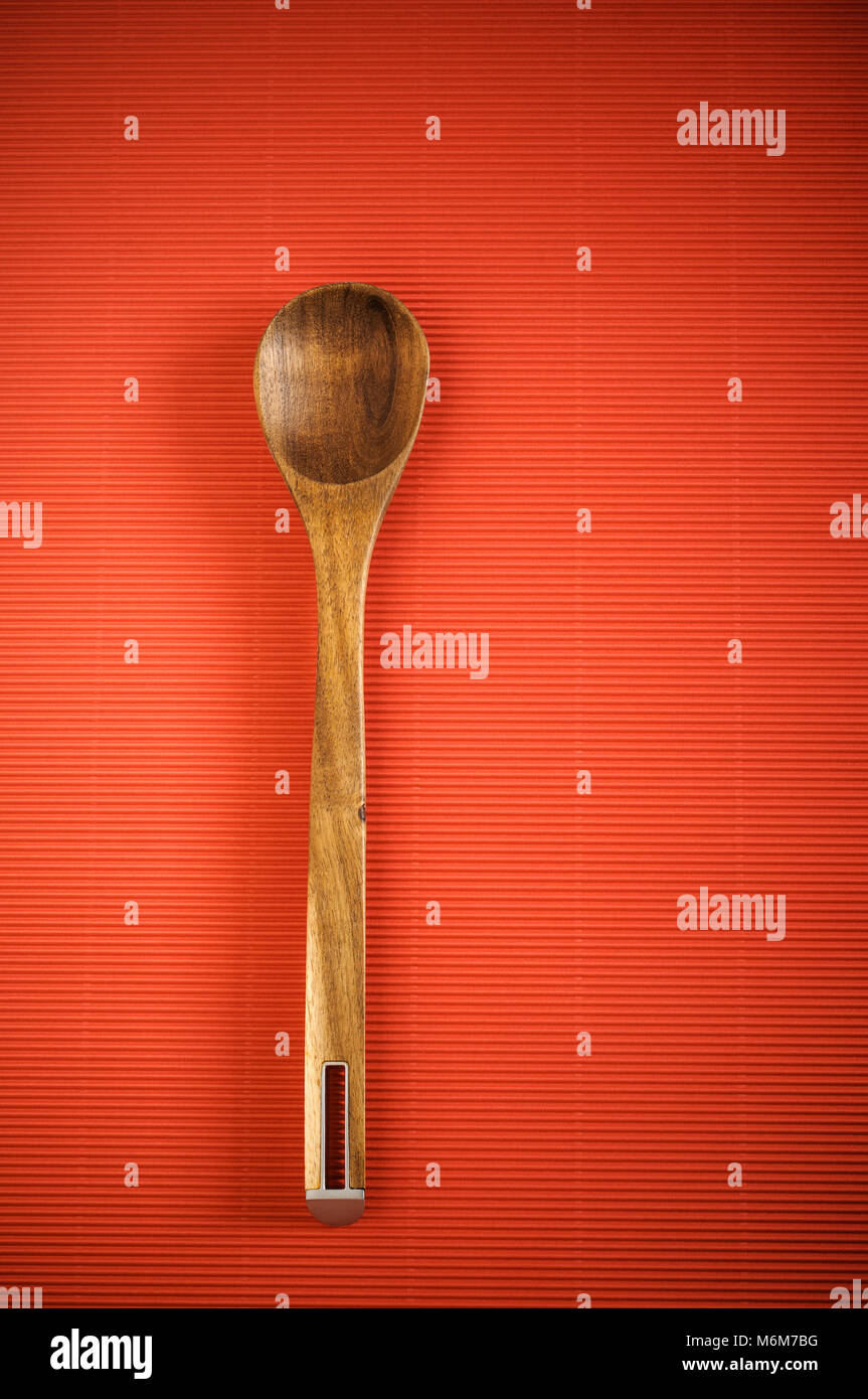 Rustic wood spoon set against vibrant orange background Stock Photo - Alamy