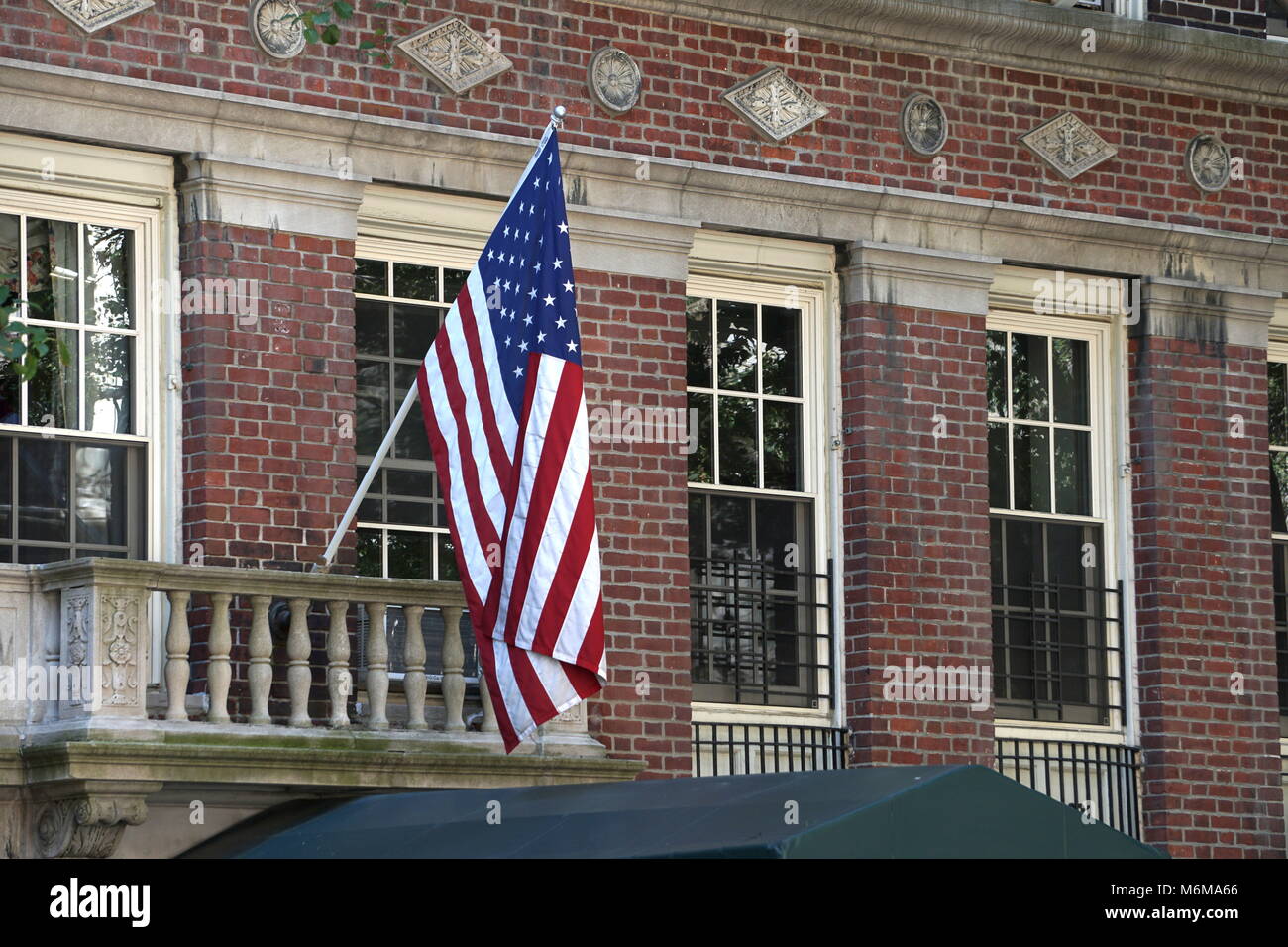 American flag hangs above the doorway to a traditional style urban ...