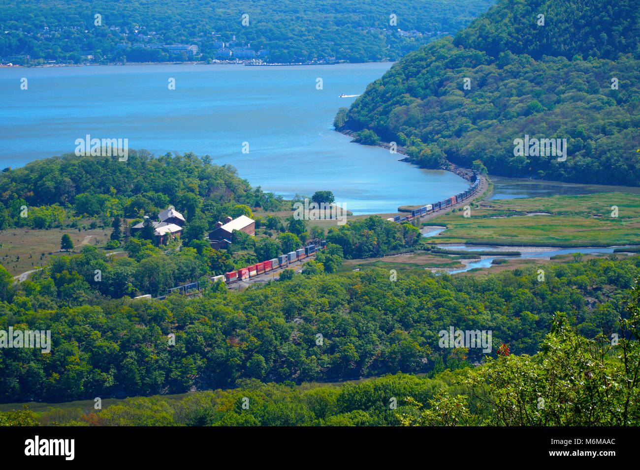 Aerial photo of freight train passing through a valley around mountains ...