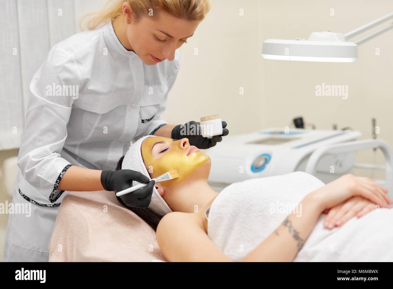 Peeling Gold Mask for Beautiful Face Skin. Cosmetologist doing beauty ...