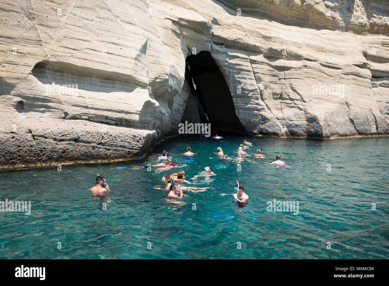 Snorkellers entering sea caves with crystal clear water at Kleftiko ...