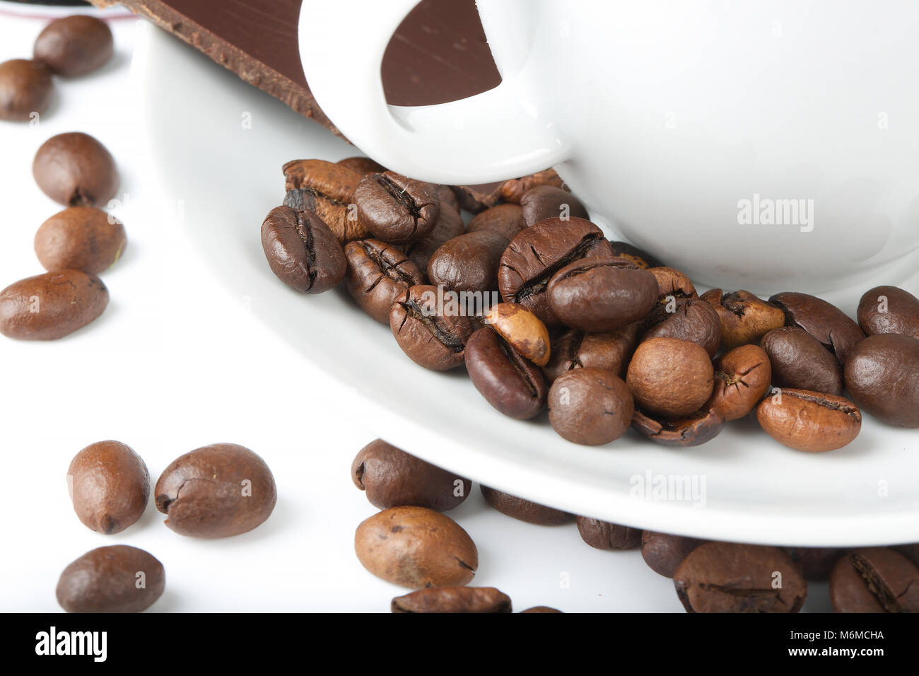 Coffee beans on a small white coffee plate.Closeup Stock Photo - Alamy