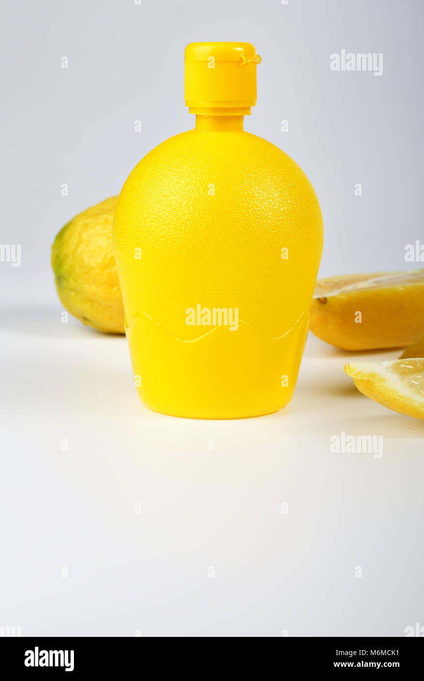 Liquid citric acid in a plastic bottle and pieces of fresh lemon ...