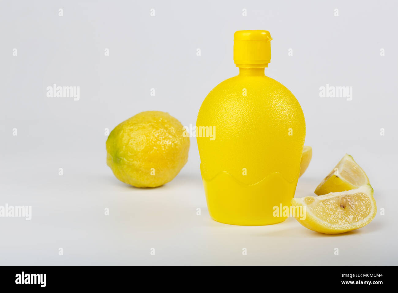 Liquid citric acid in a plastic bottle and pieces of fresh lemon ...